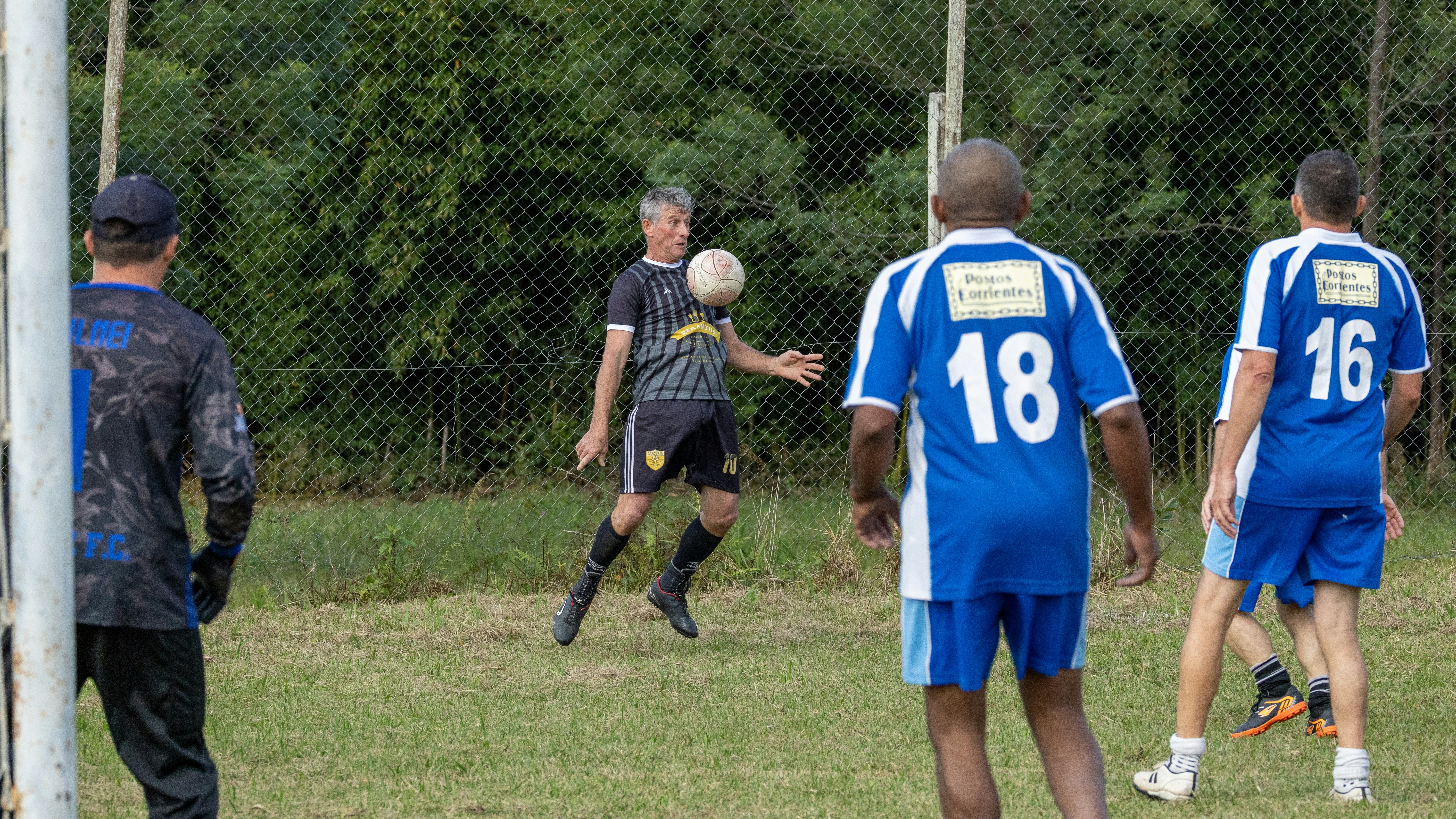 Midfield Moment: Defender Prepares as Ball Arcs Toward the Keeper