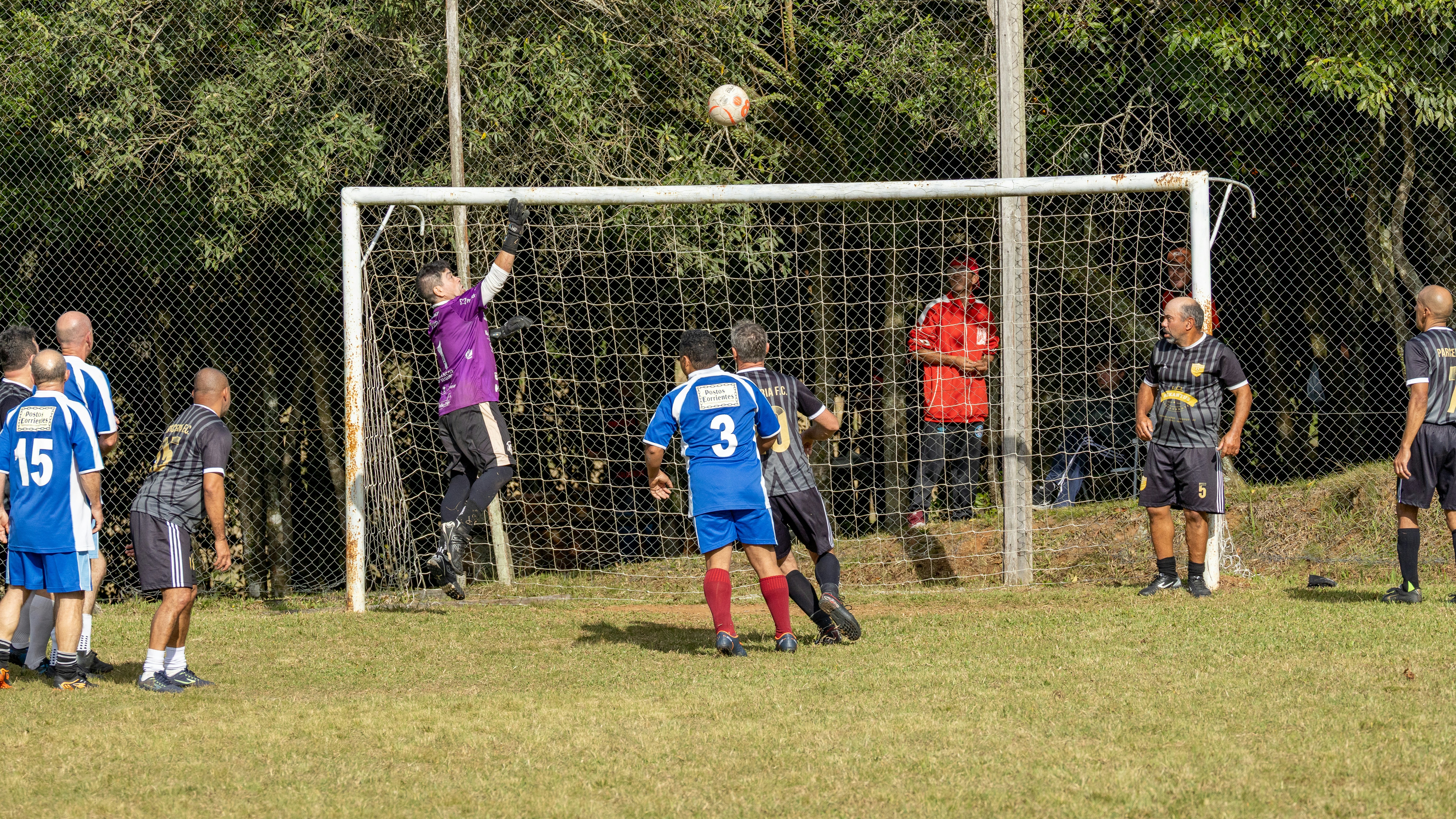 Goalkeeper jumps to block the ball during a soccer match.