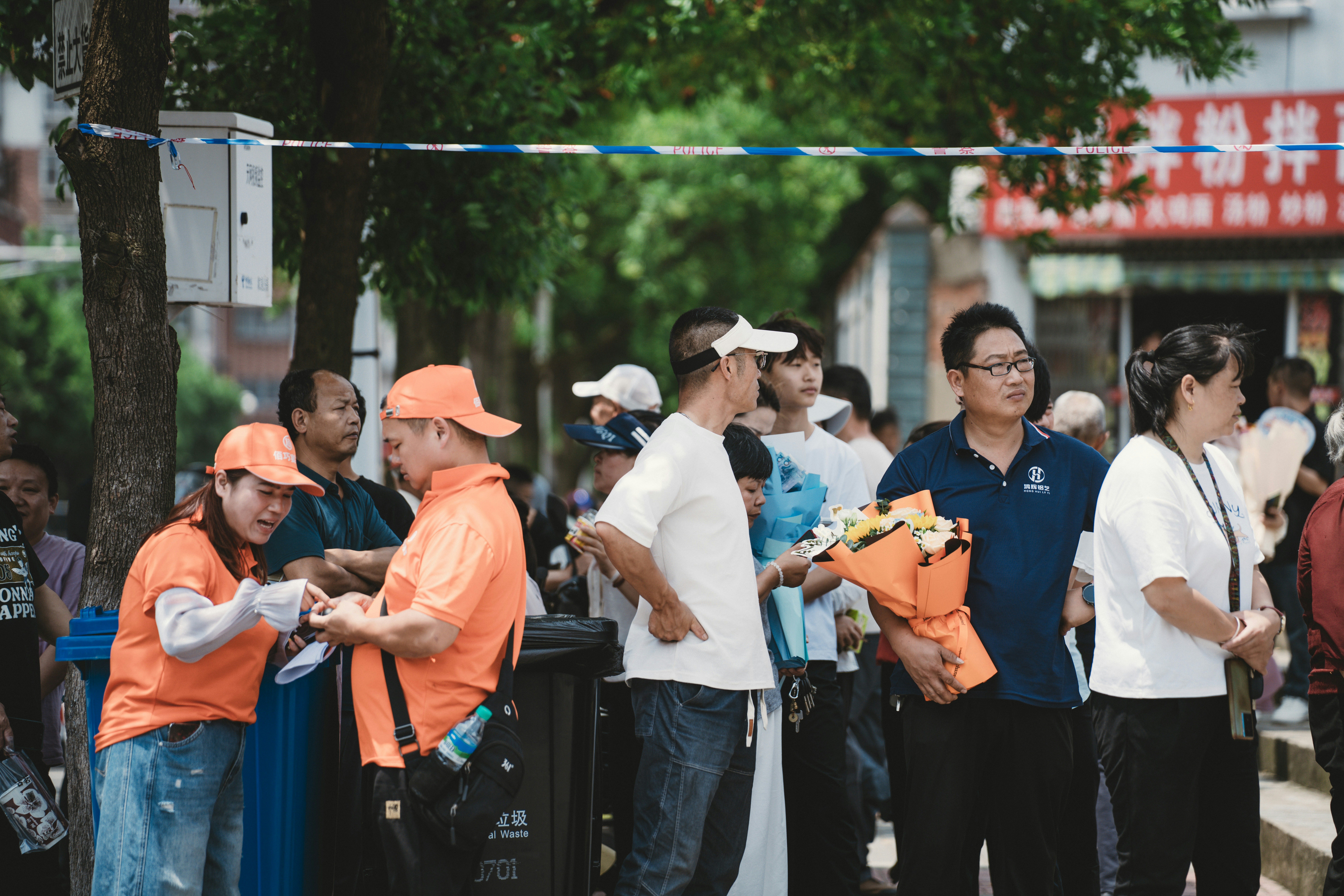 Midday Crowd Relay: Orange Hats, Orange Vests, and a Shared Task