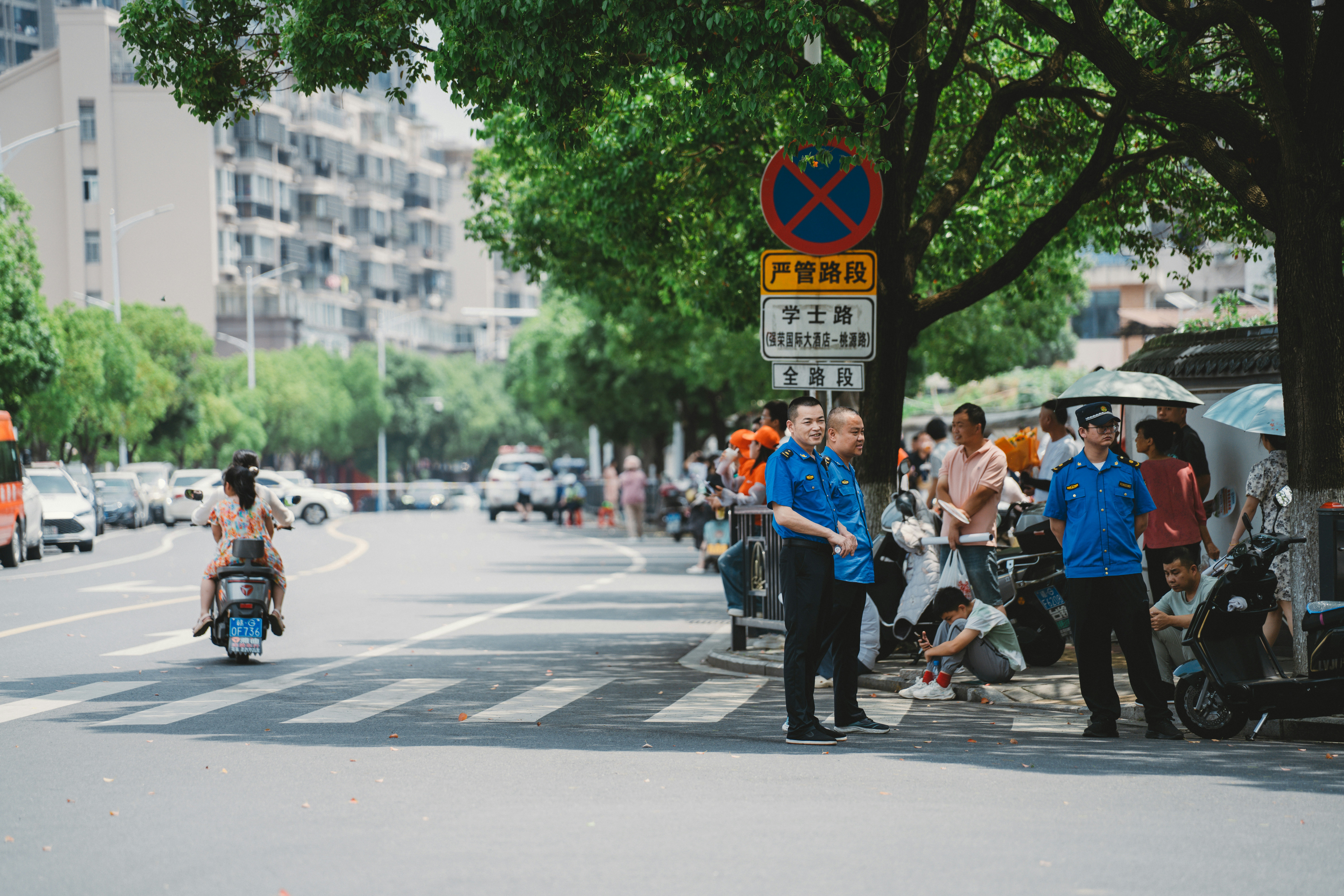City Street Vigil: Officers and Passersby at a Busy Crosswalk