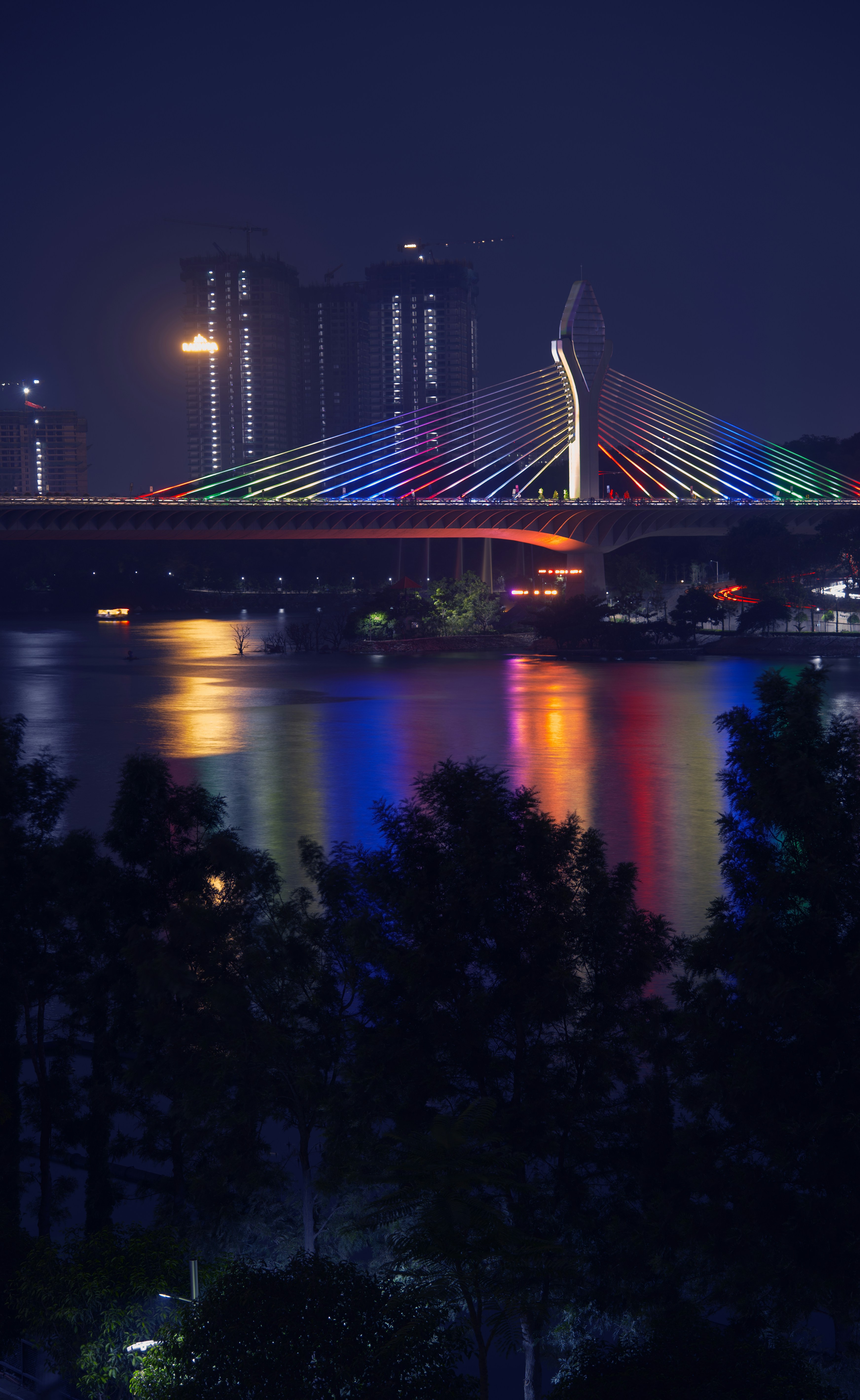 Rainbow Arc over the River: Night Bridge Illumination