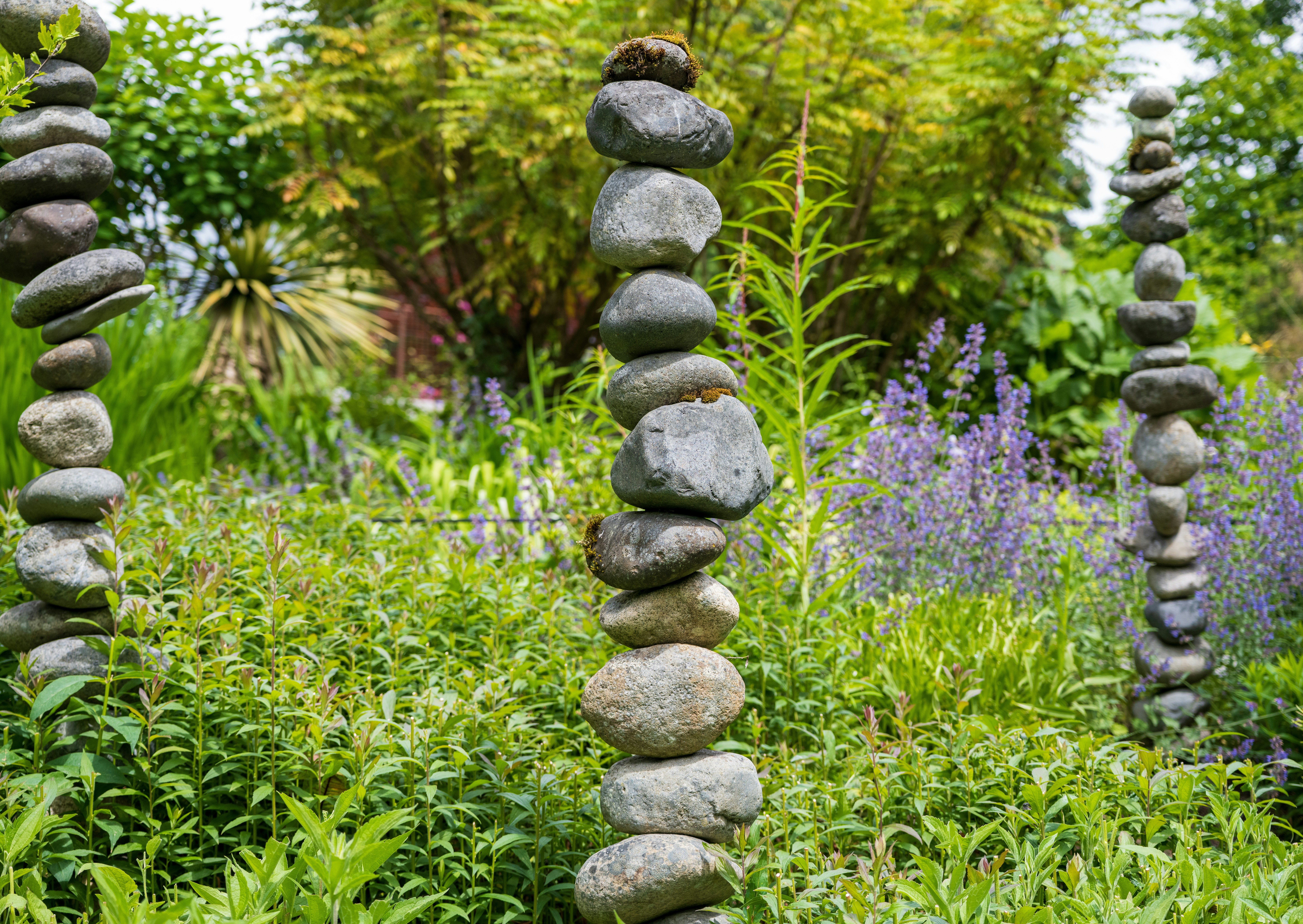 Balanced Zen: Stacked Stones in a Lush Garden