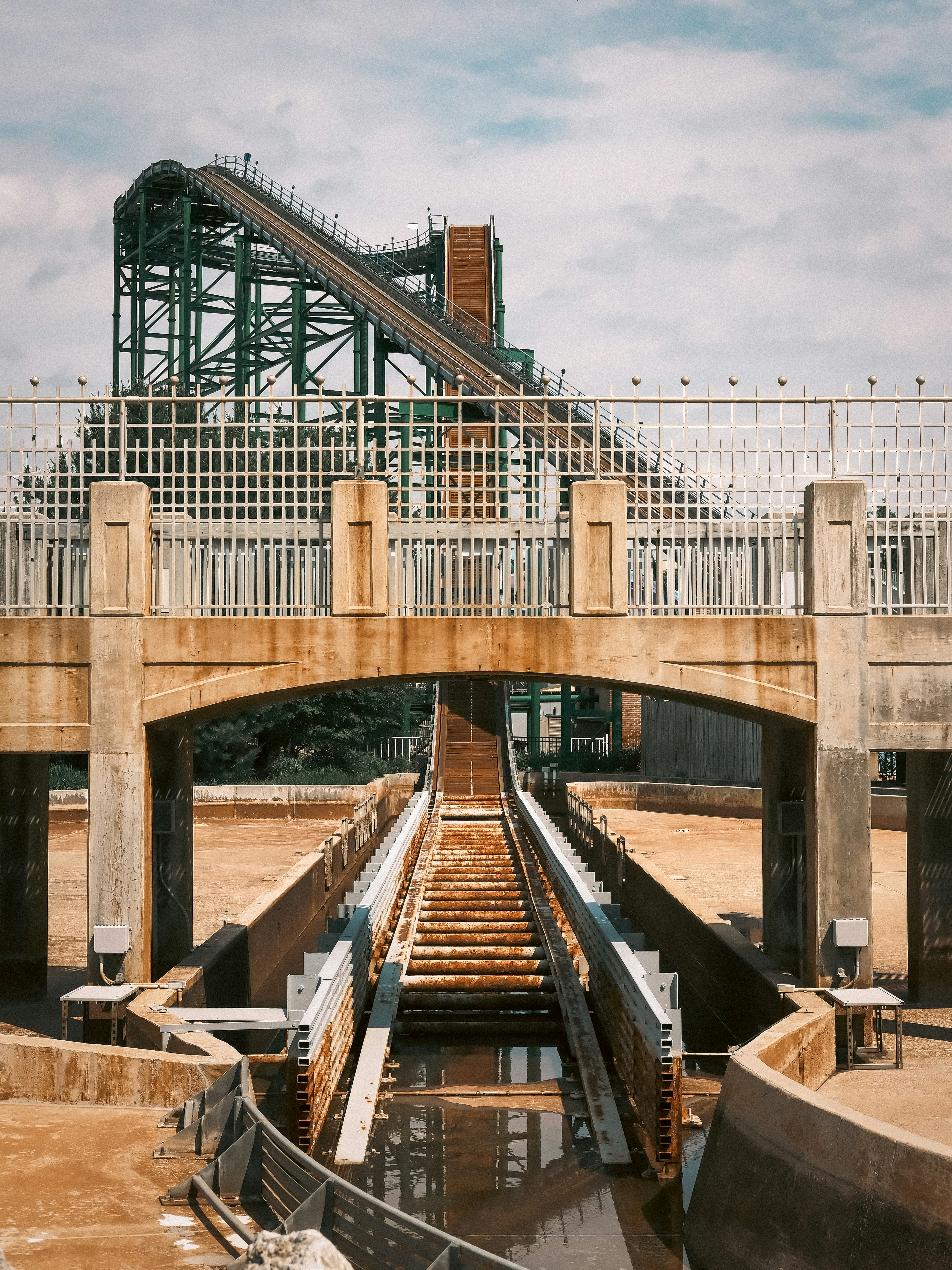 A large log flume ride with a concrete bridge overhead.