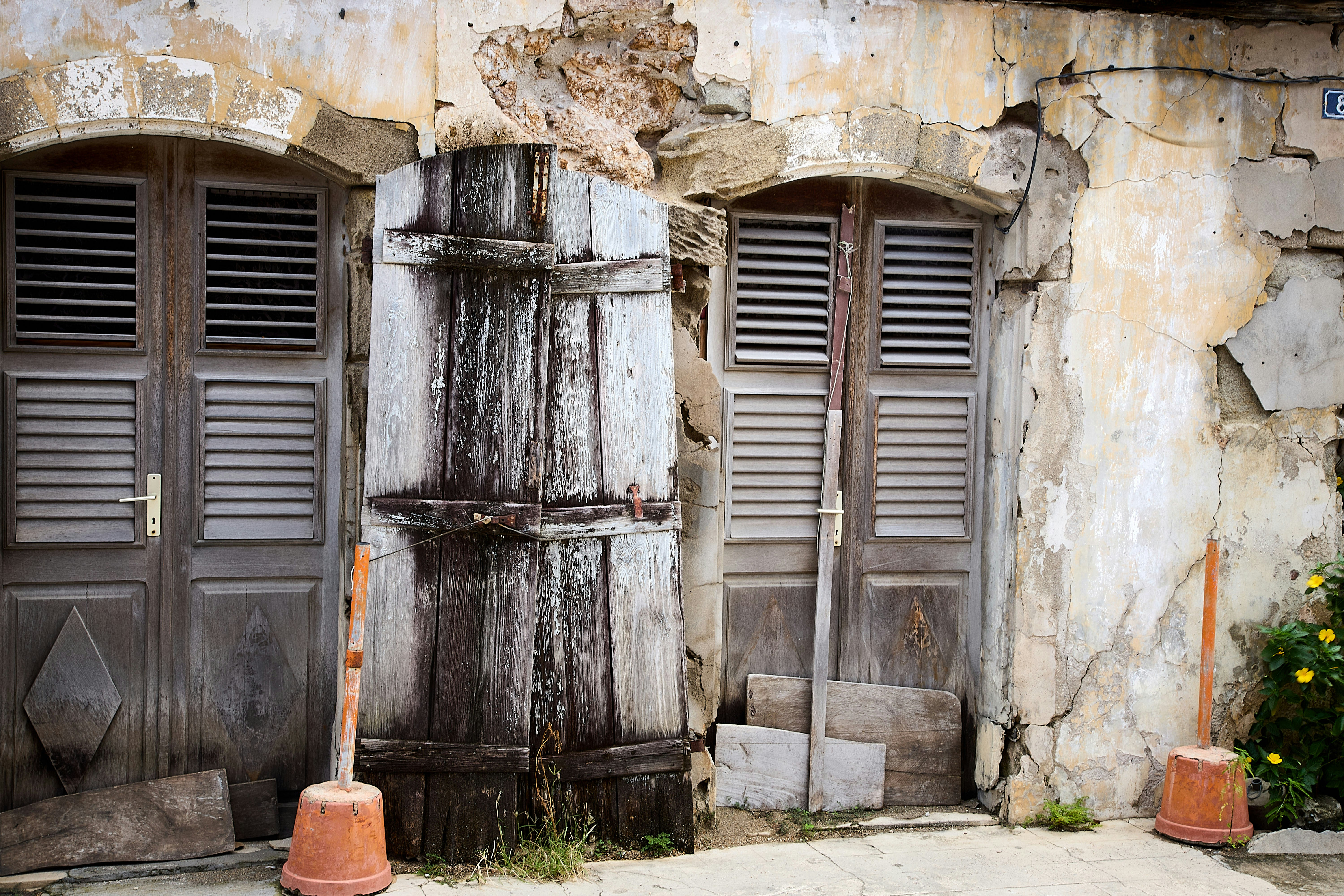 Weathered Doors and Aged Barrel: A Quiet Wall of Time