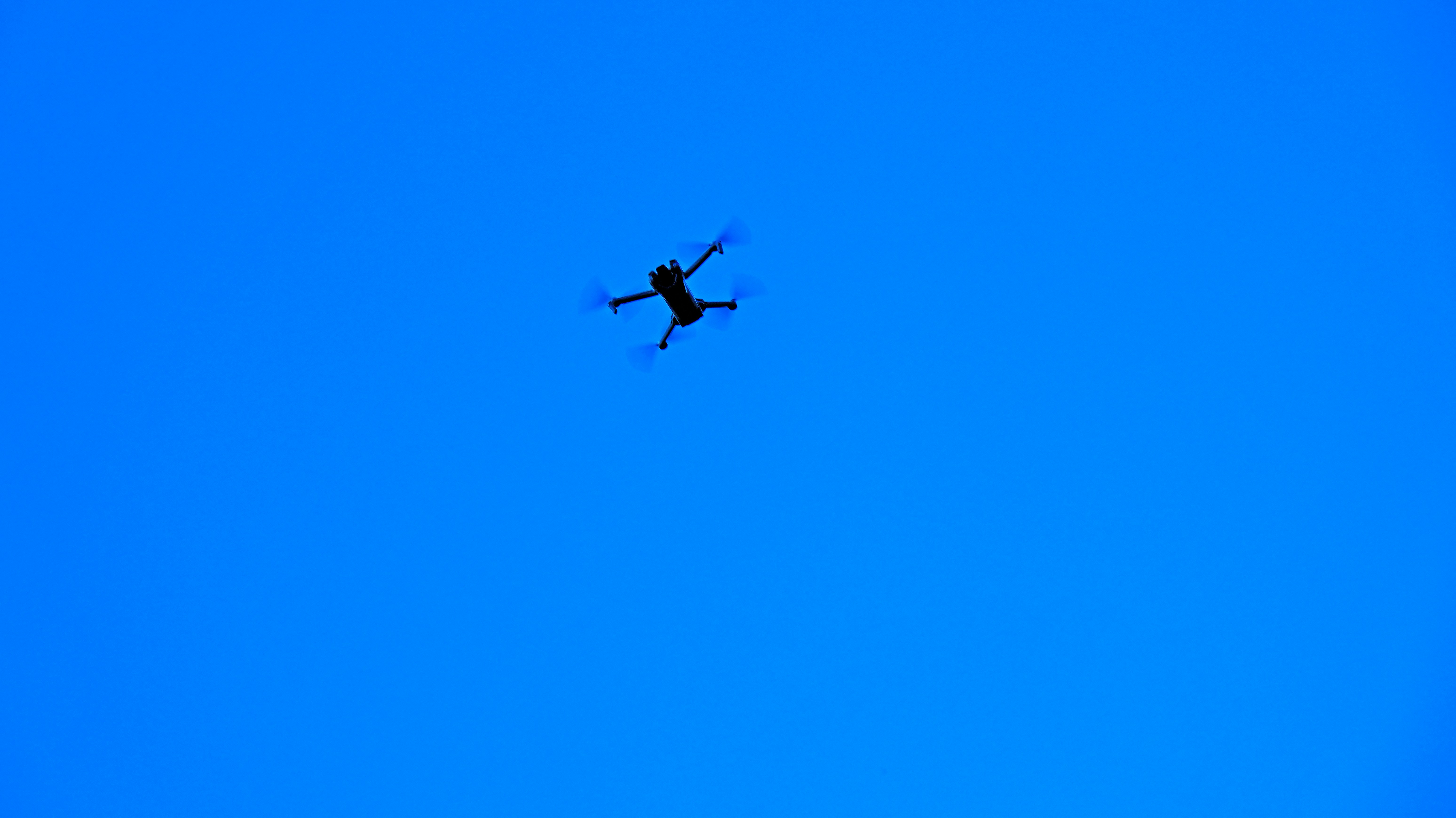 Midair Shadow: A Solo Drone Drifts Across an Expansive Azure Sky