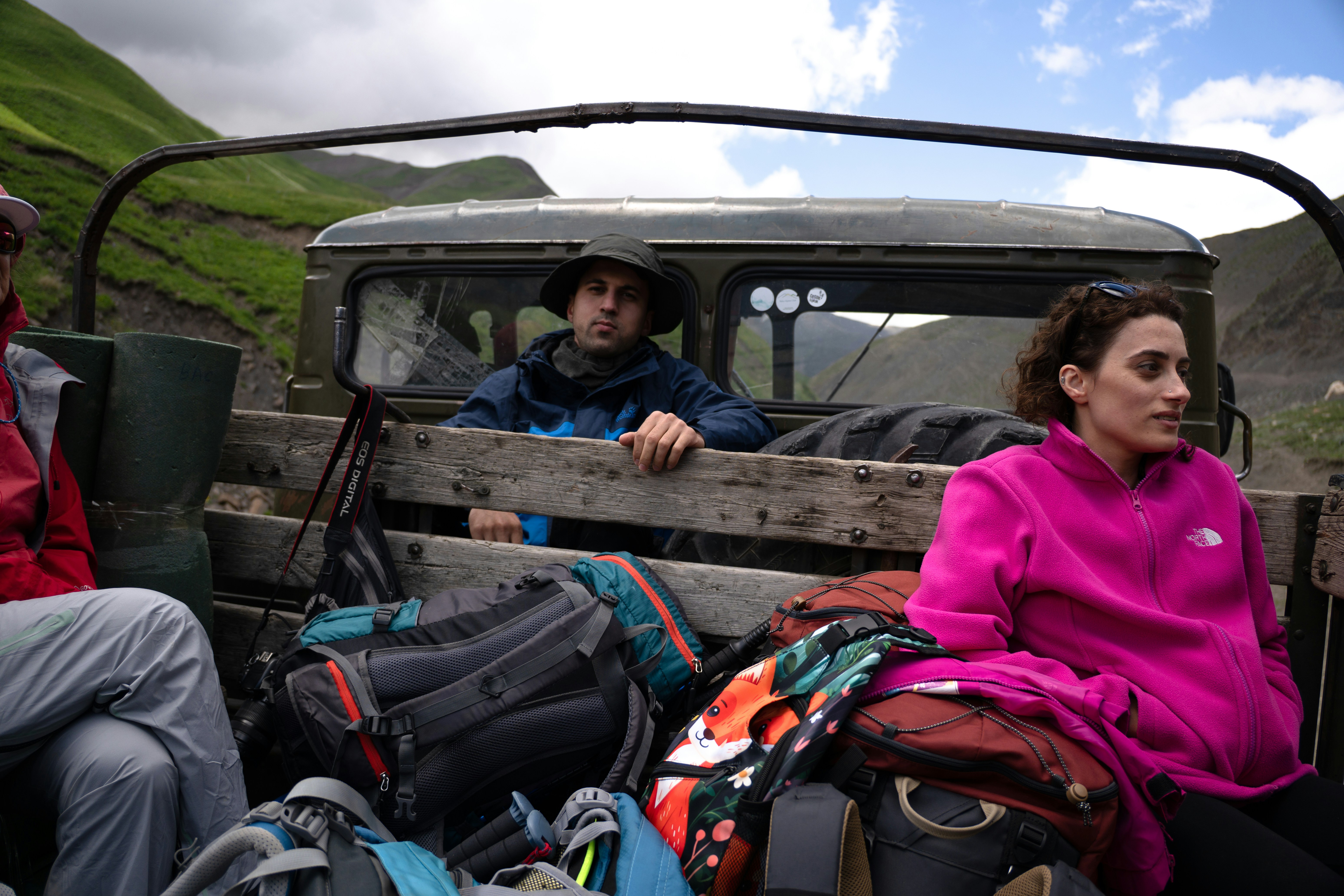 Pink fleece, rugged terrain, and a wind-swept ride: passengers tucked into a loaded jeep