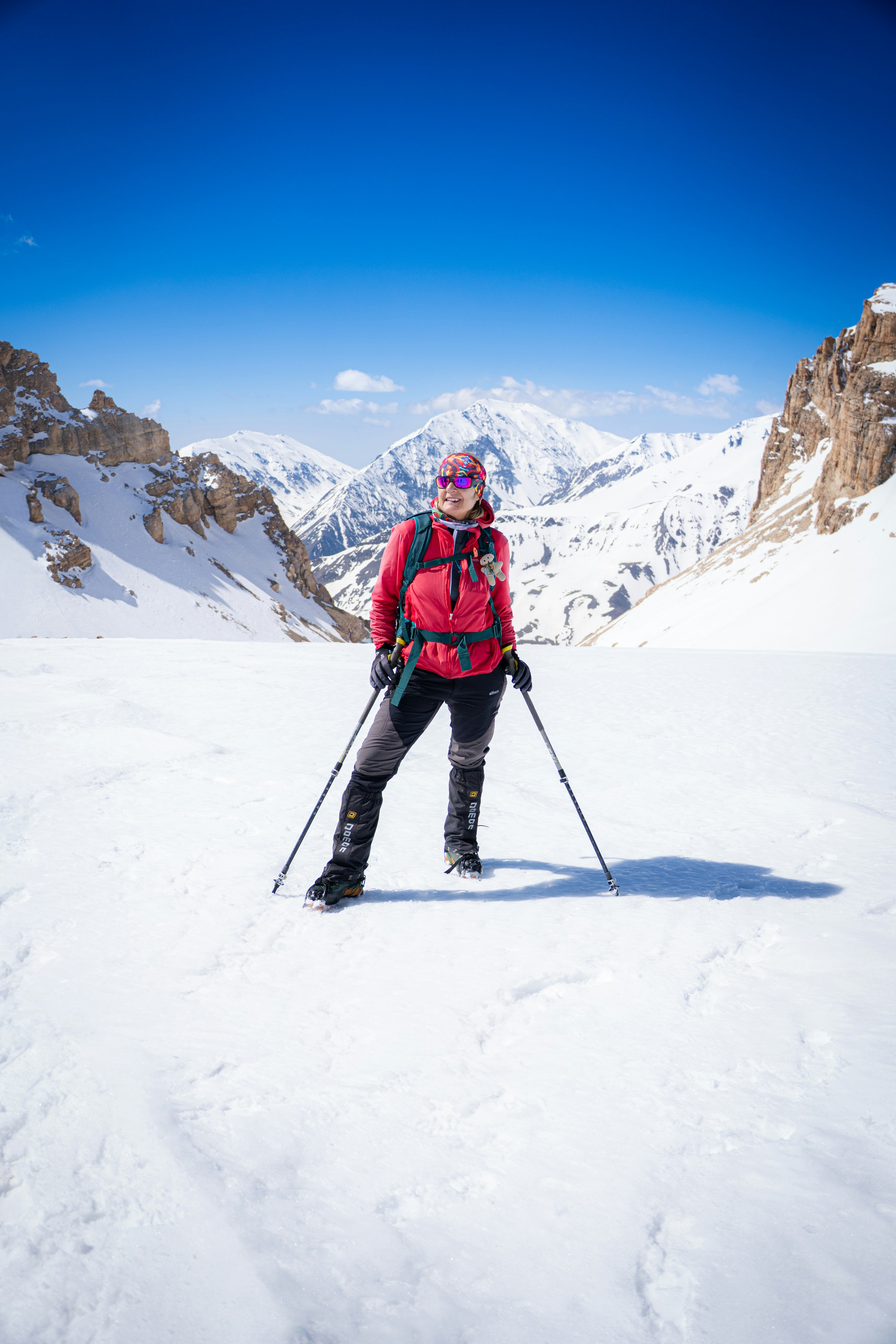 Snowbound Summit: A Climber in Crimson Amid Renowned Peaks