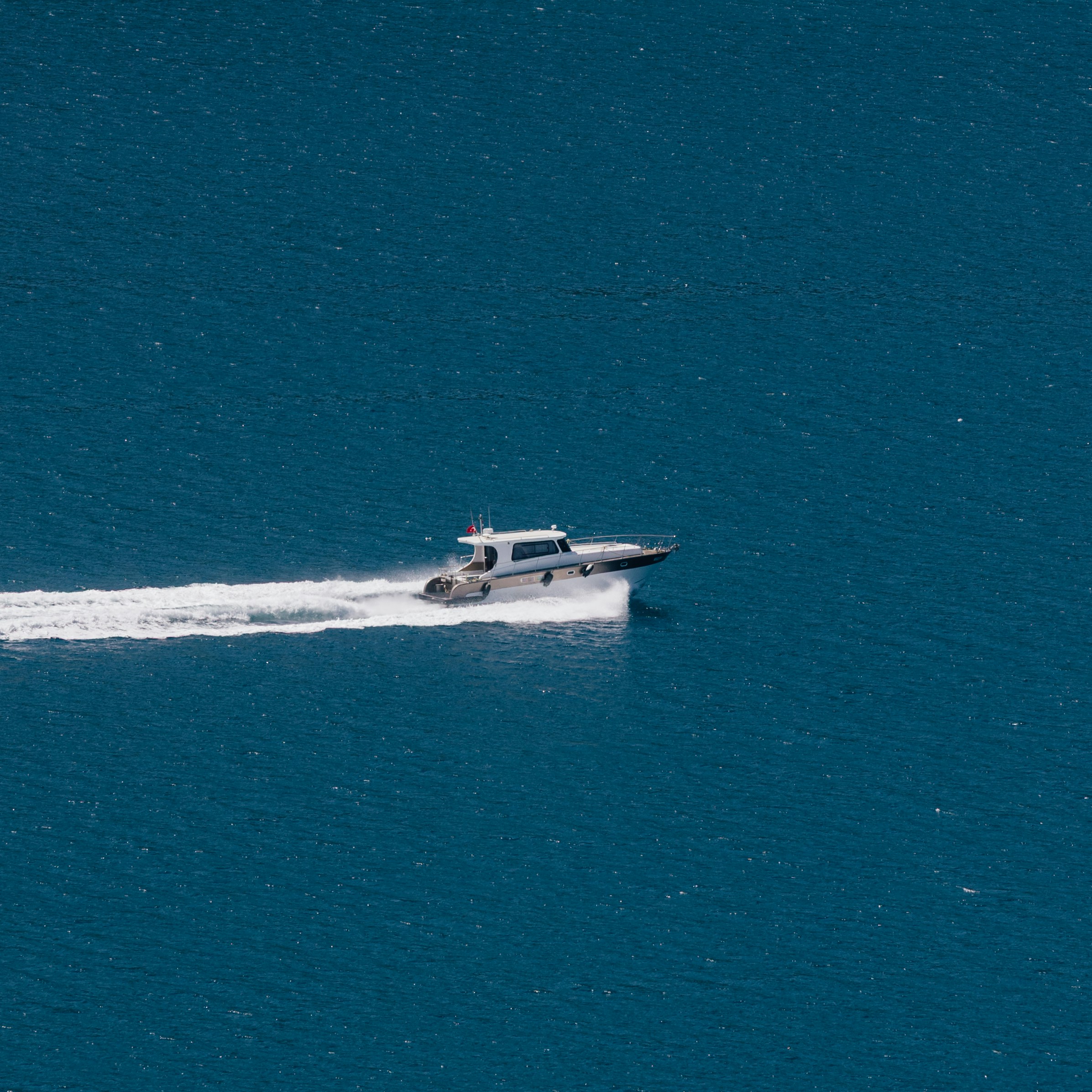 A sleek motorboat carving a wake through deep blue seas