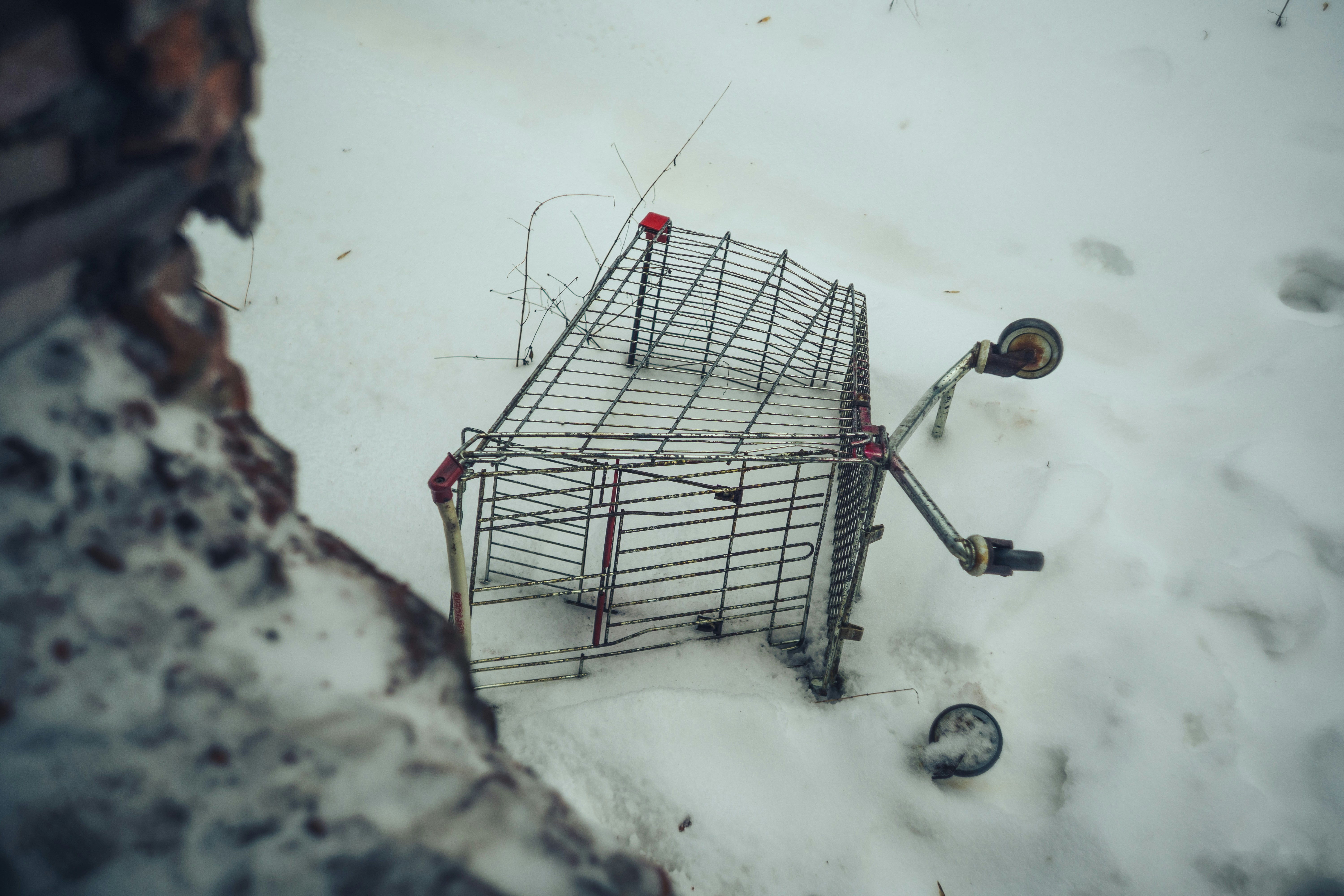 Icy Remnant: A Lone Shopping Cart Half-Buried in Snow