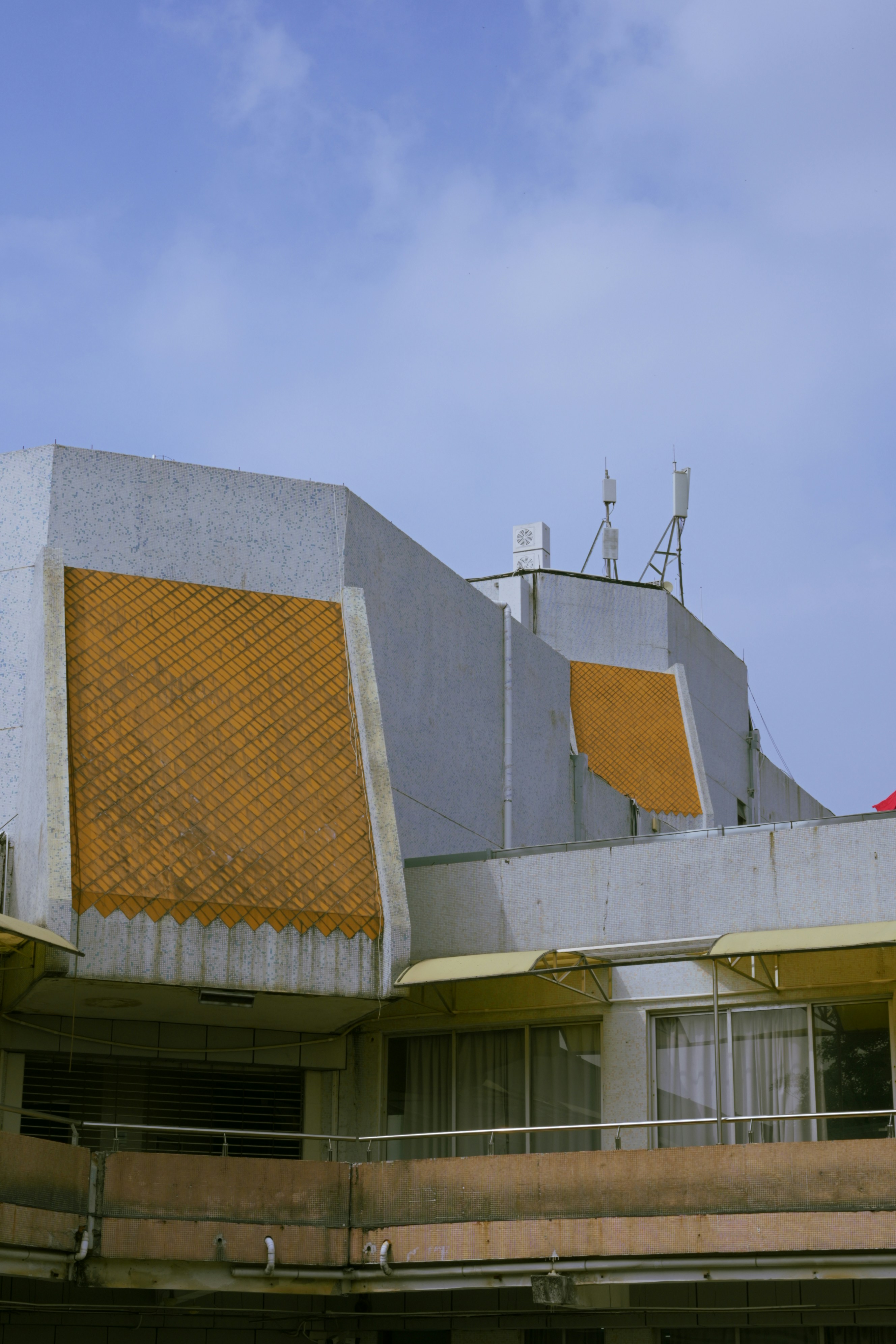 A building with textured orange panels against a blue sky.