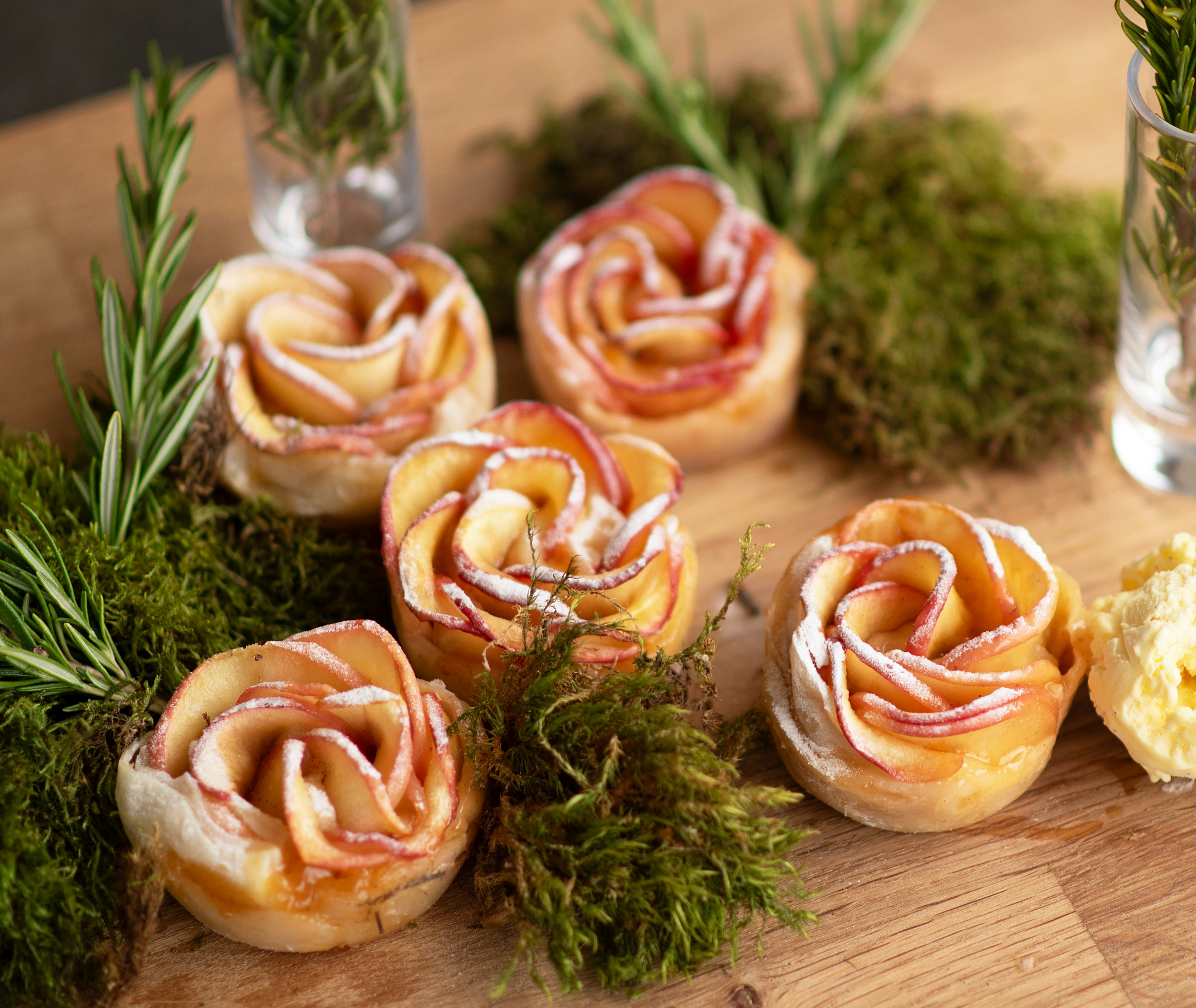 Rose-Shaped Pastries on a Rustic Board, Framed by Greenery