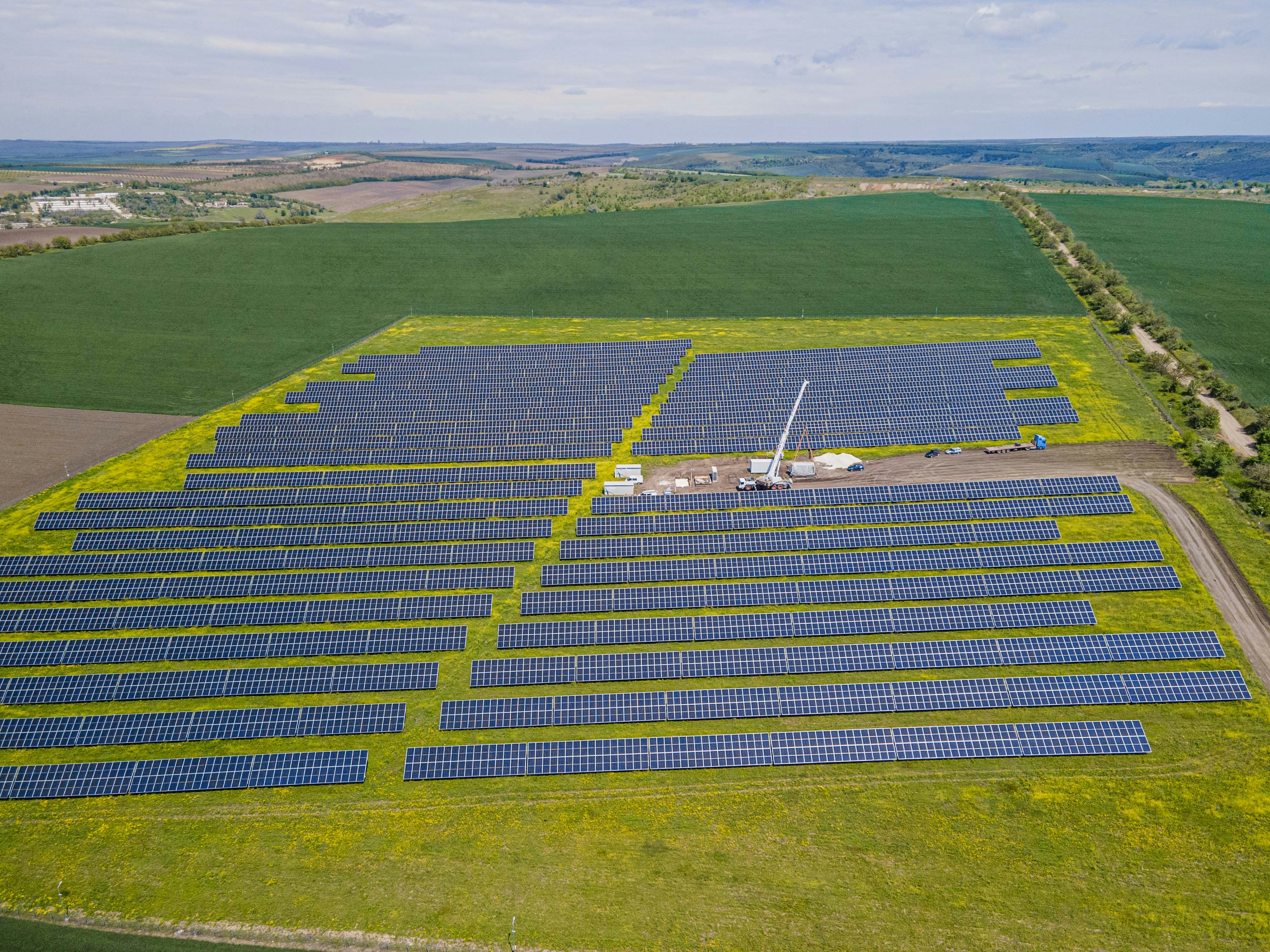 Sunlit Grid: Aerial Rows of Solar Panels in Rural Harvest