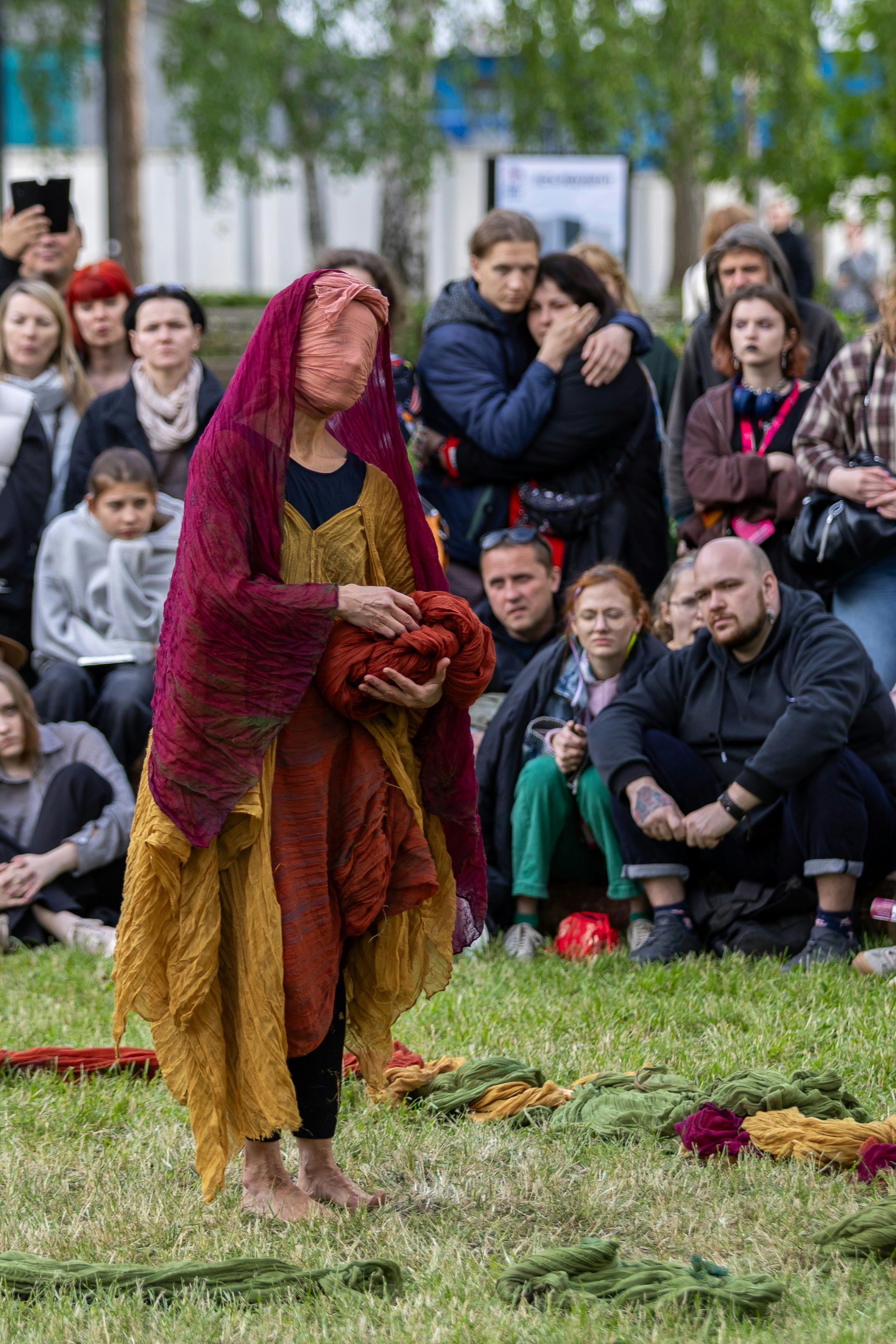 Veiled Dignity: A Cloth-Draped Figure Surrounded by Onlookers