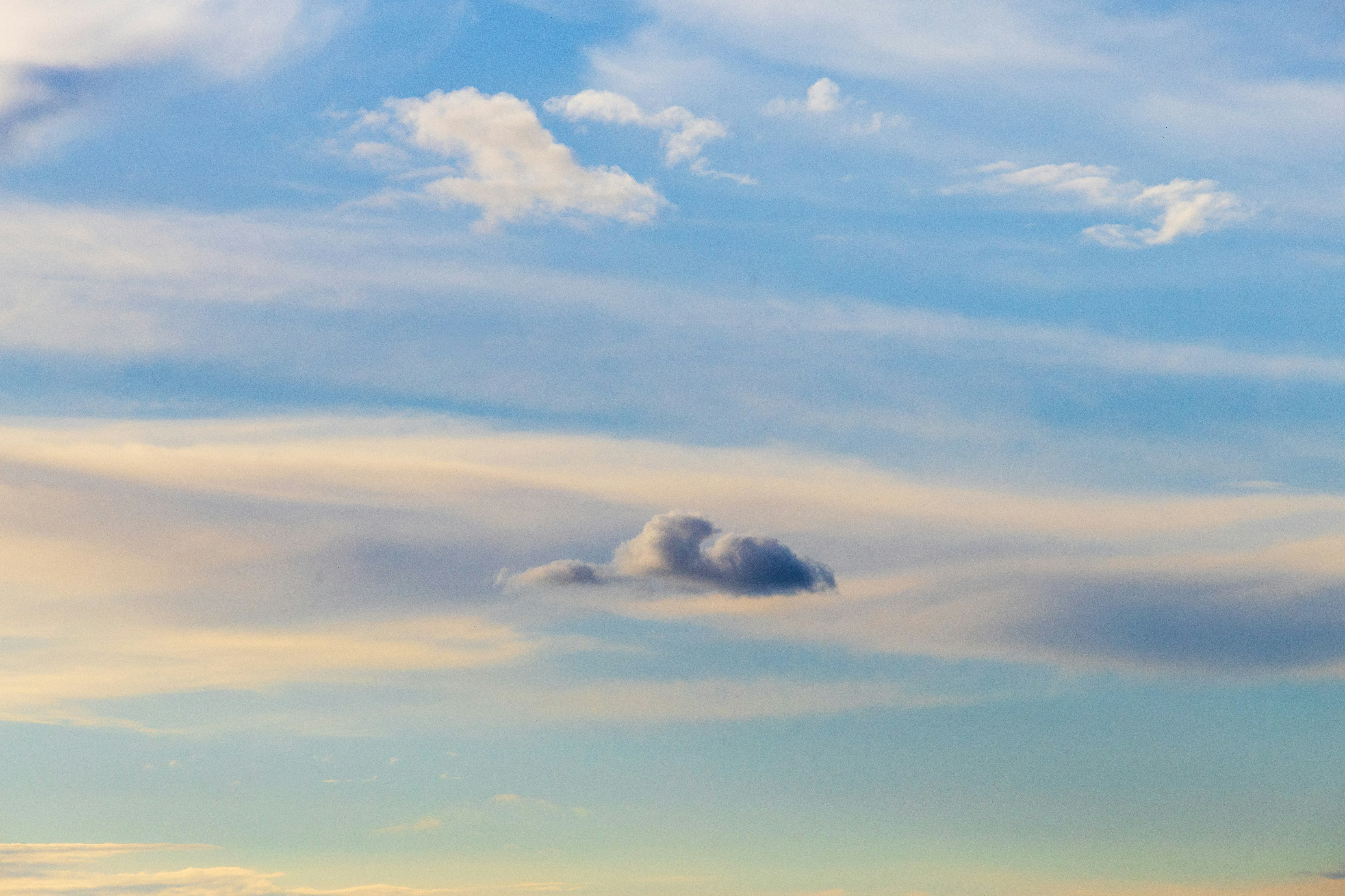 A solitary cloud drifting along a pastel sky at dusk