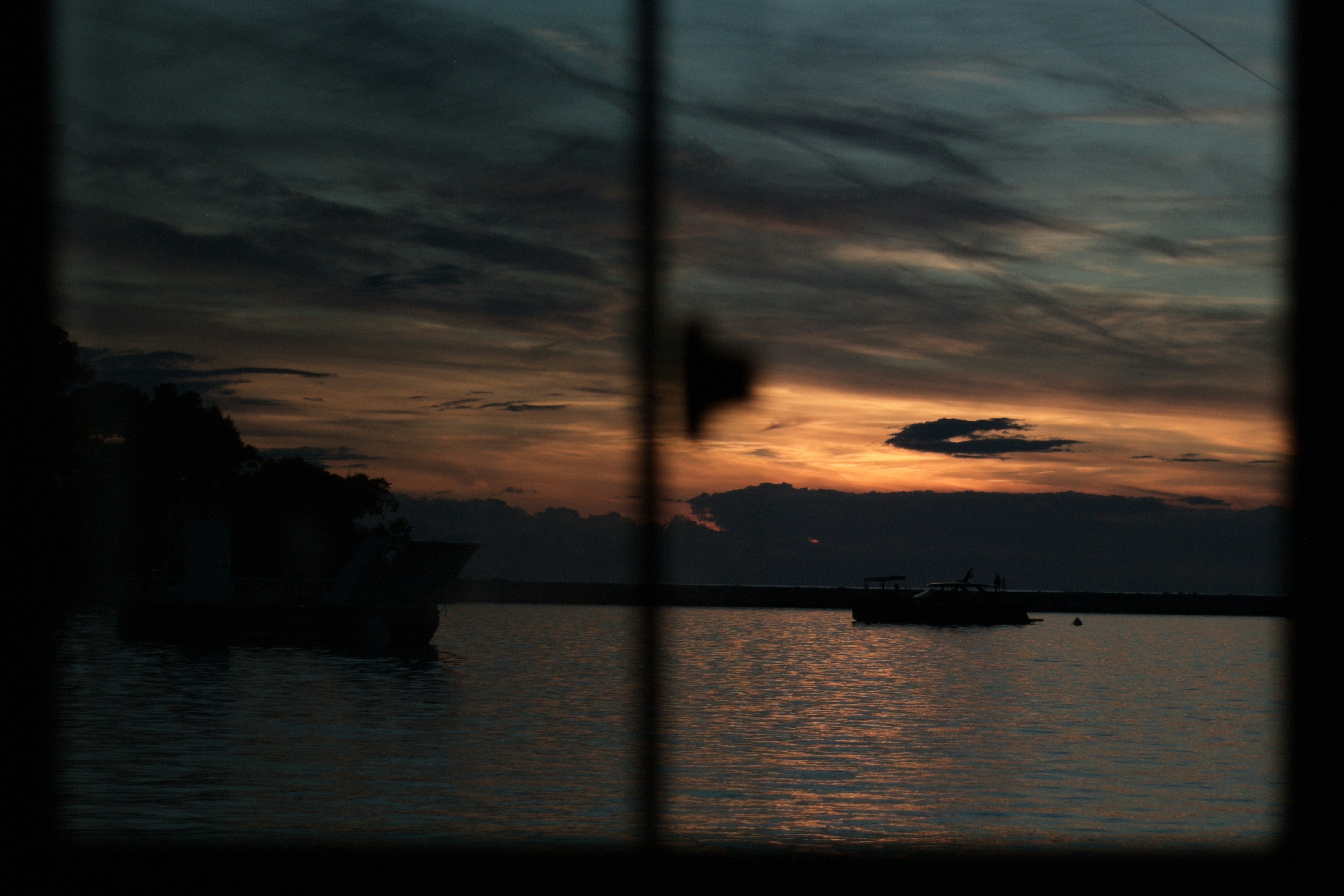 Sunset at the Pier: silhouettes and ripples across calm water