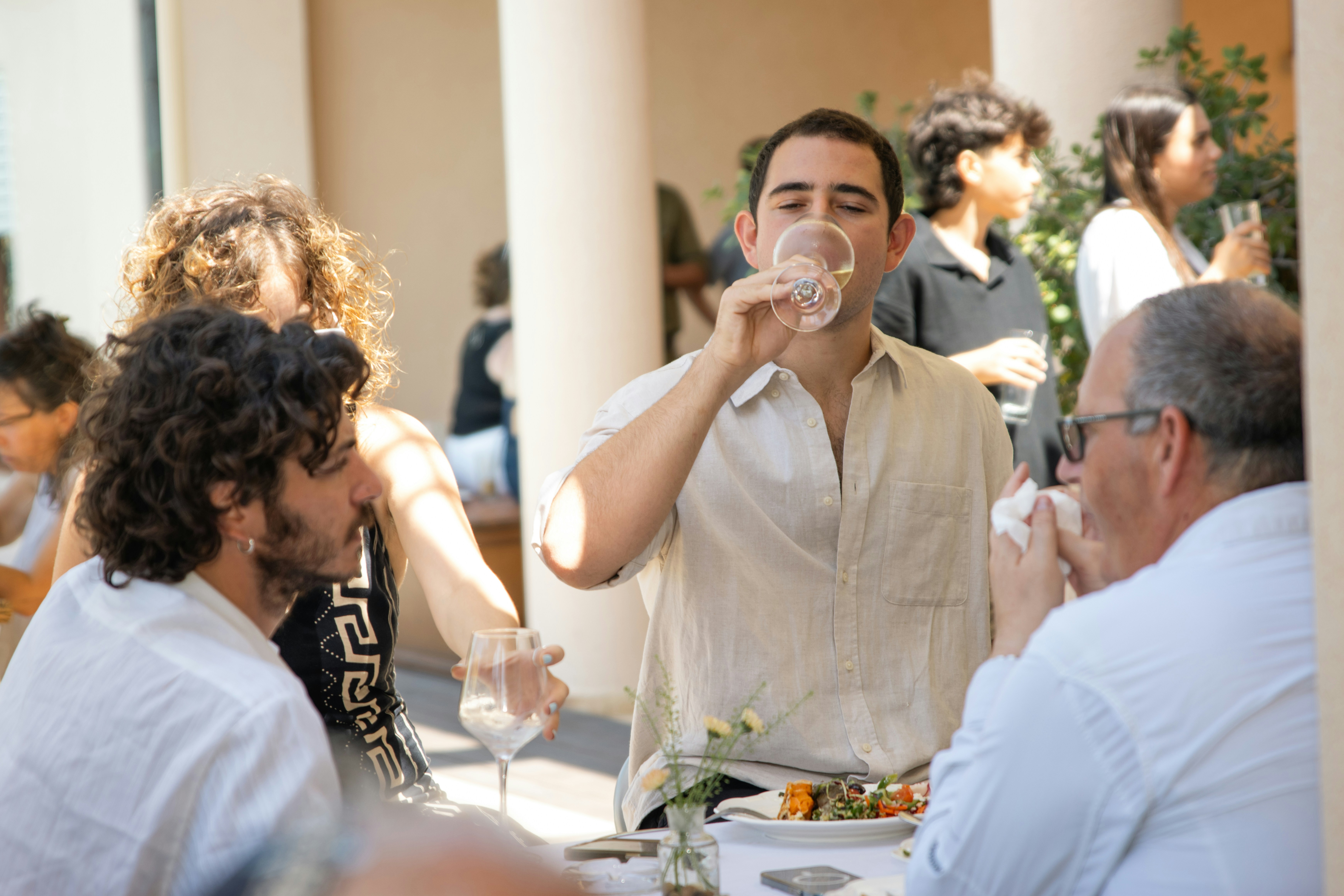 Toast at a sunlit courtyard: friends share drinks and conversation
