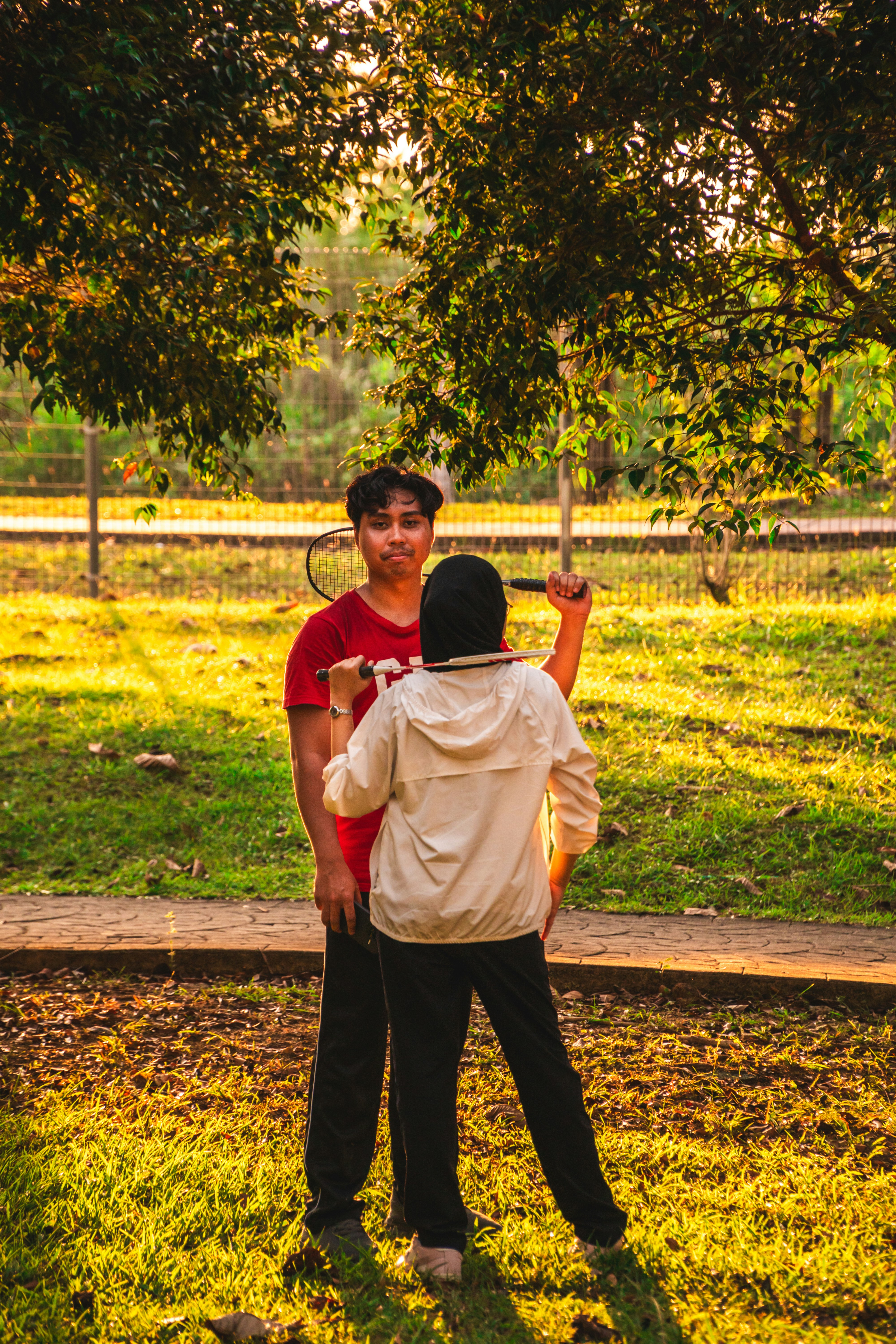 Two Friends in a Sunlit Park: A Quiet Moment Amid Green Canopies