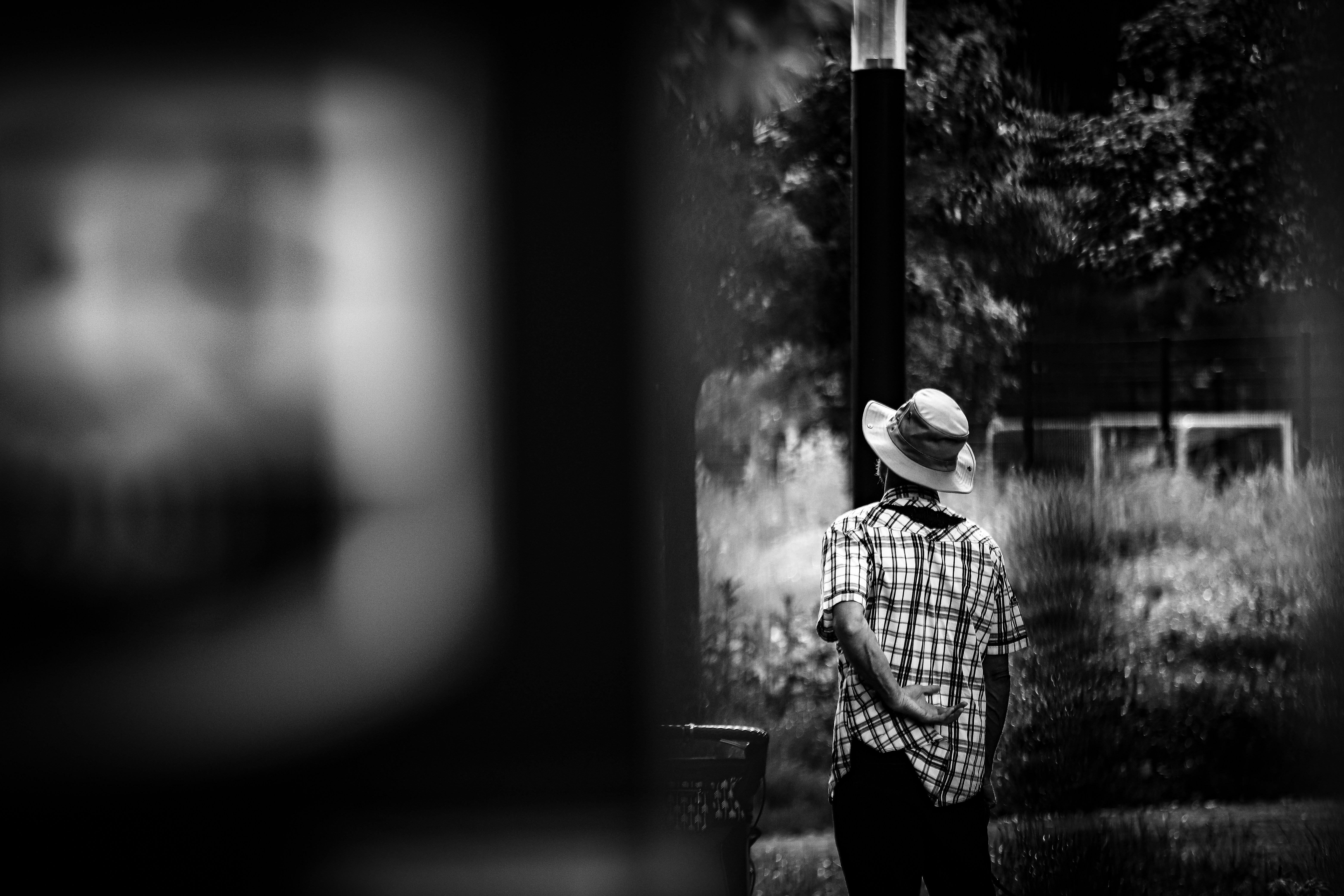 Quiet Portrait in a Park: A Hat, a Shirt, and a Silent Gaze