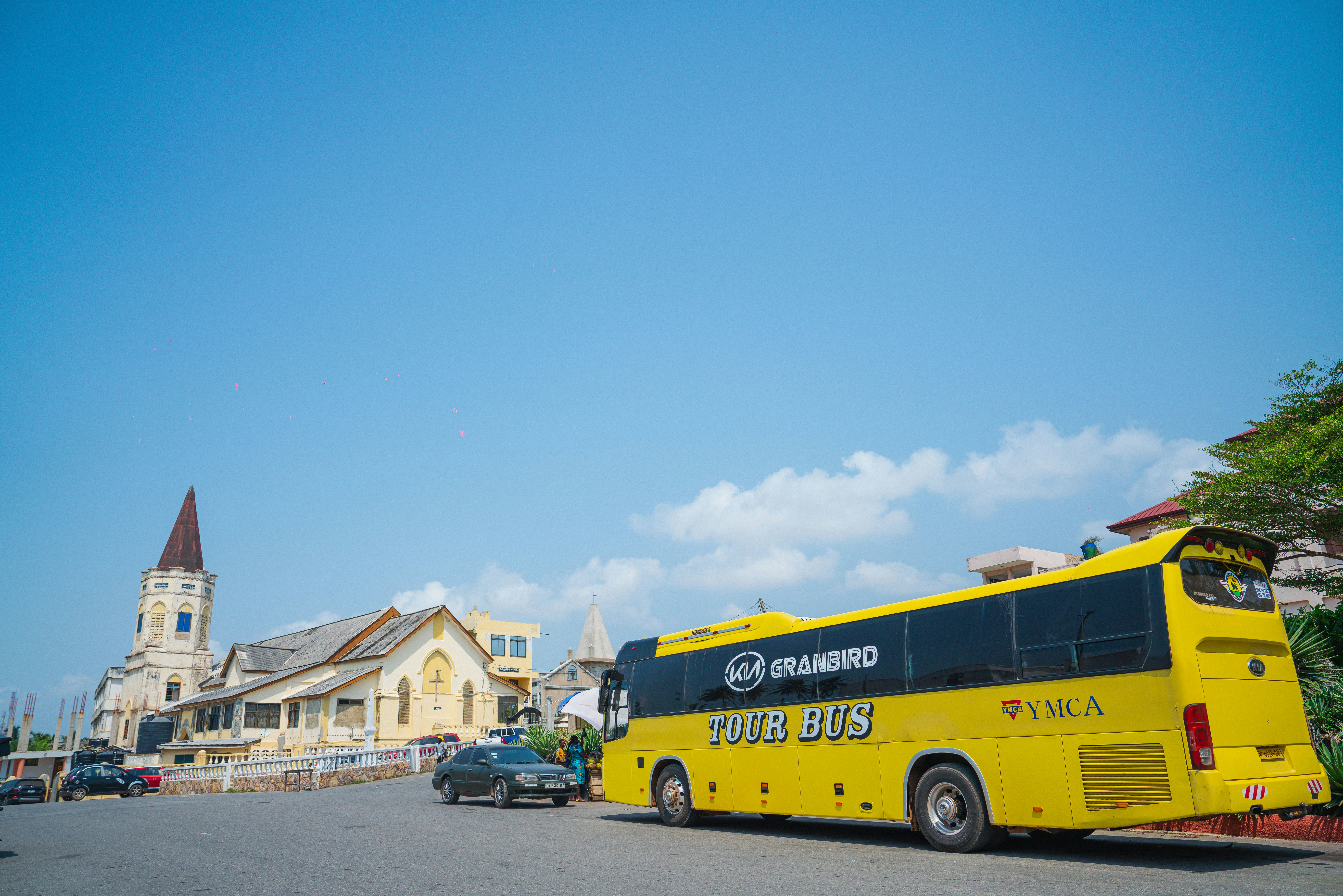Yellow Tour Bus at a Sunlit Coastal Town