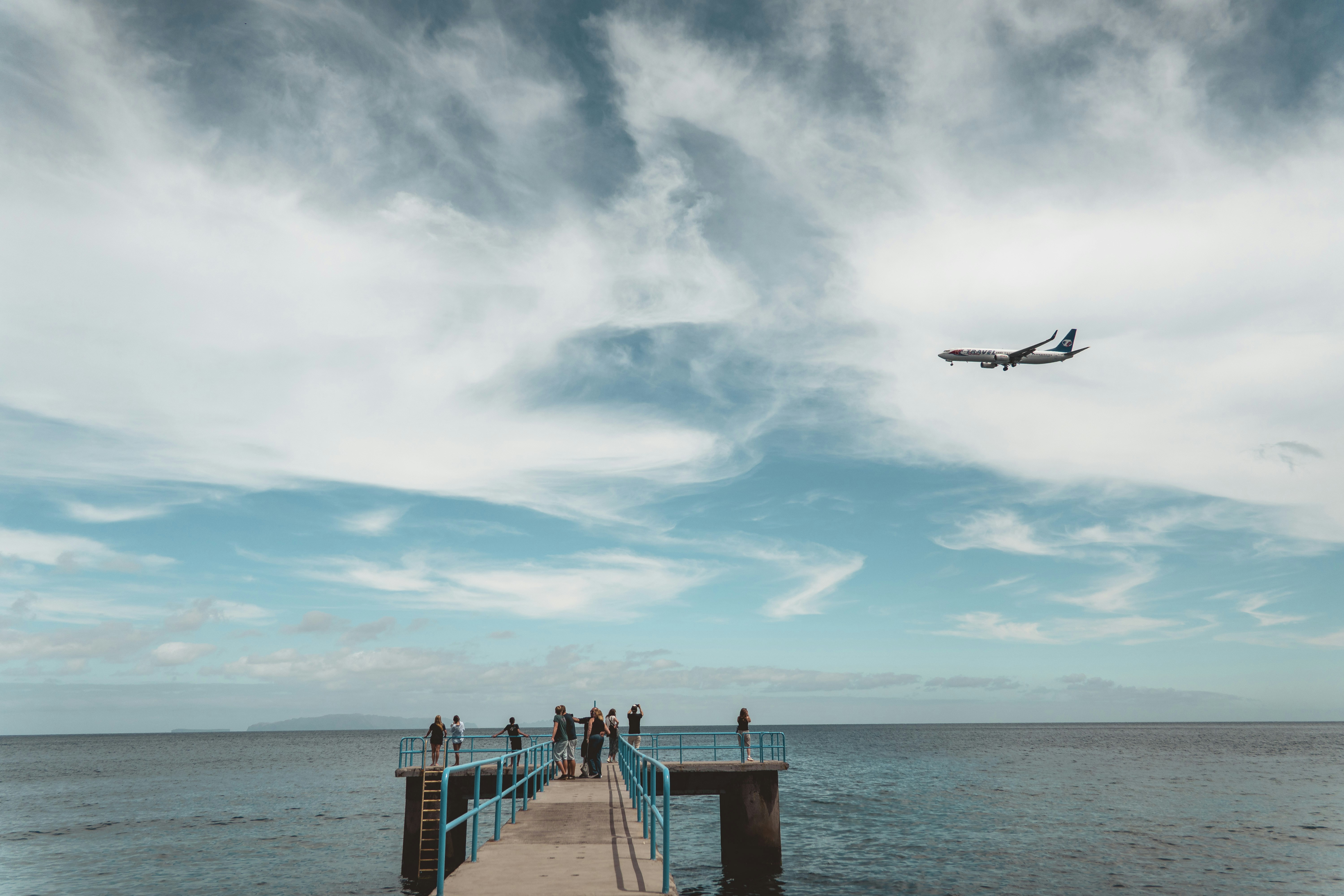 Pier at Sea: A Quiet Gathering Beneath Expansive Skies