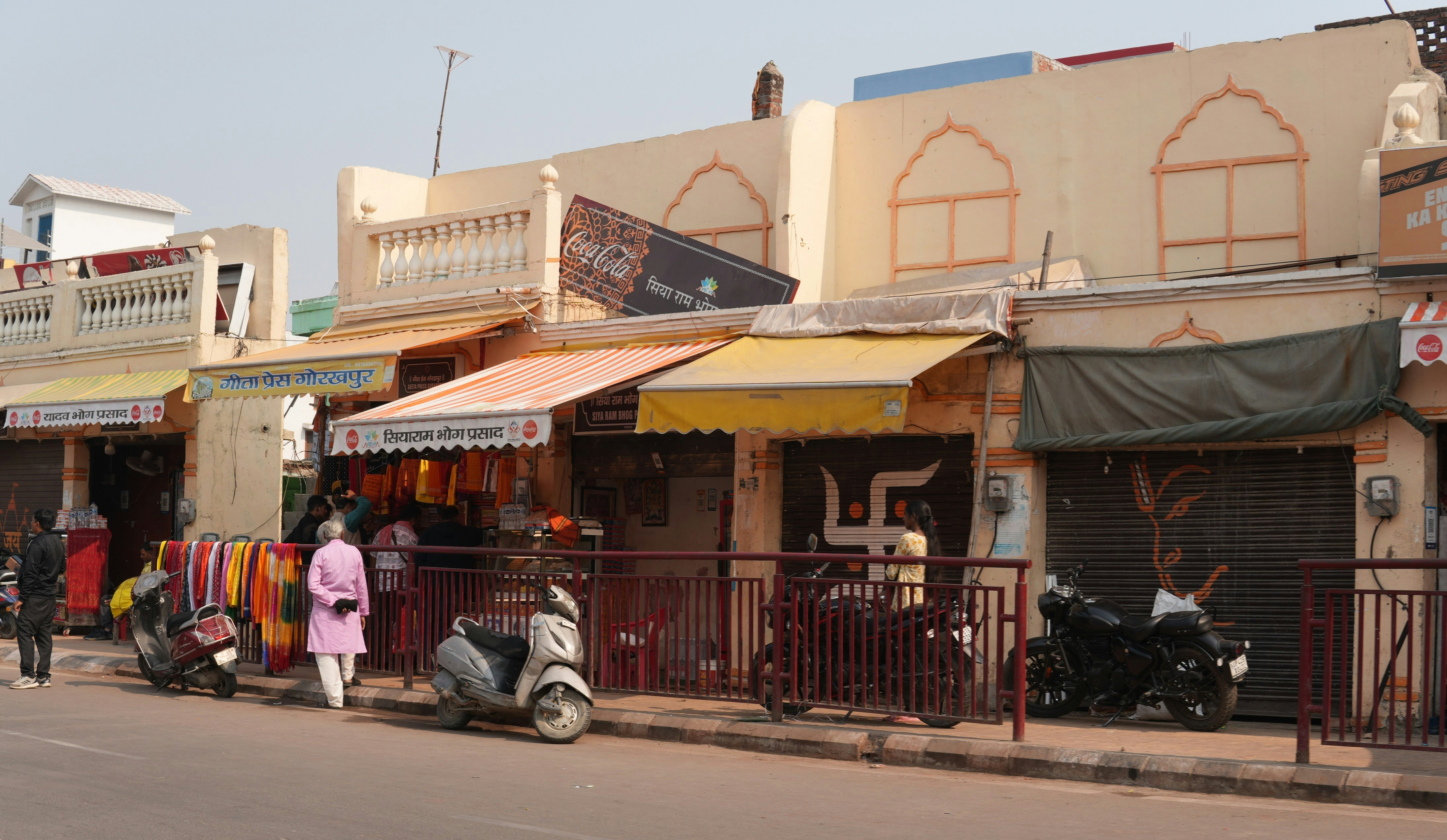 Sunlit Bazaar Facade with Colorful Awnings and Street Life