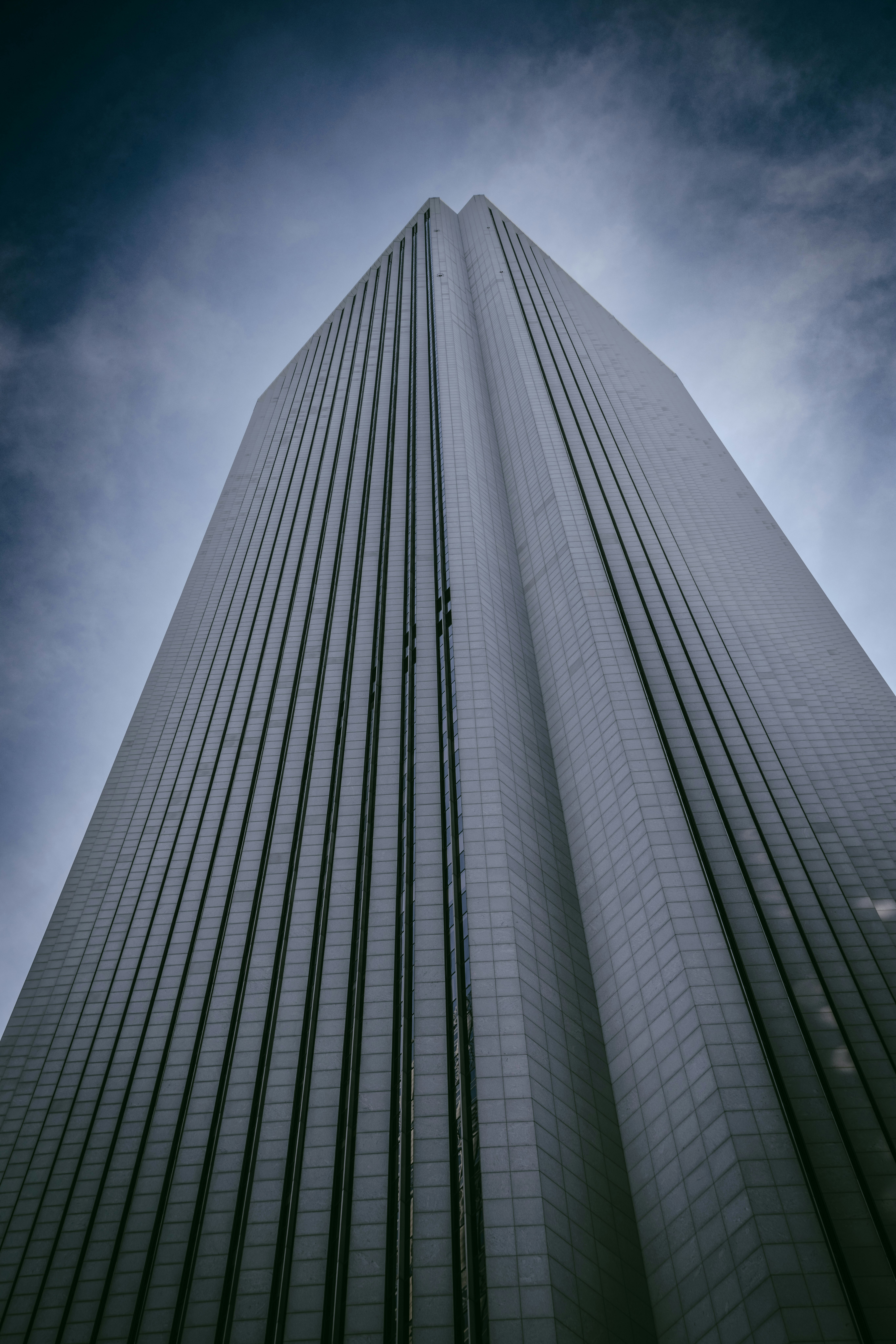 Vertical Prism: A Skyward Facade Reaching Through Clouds