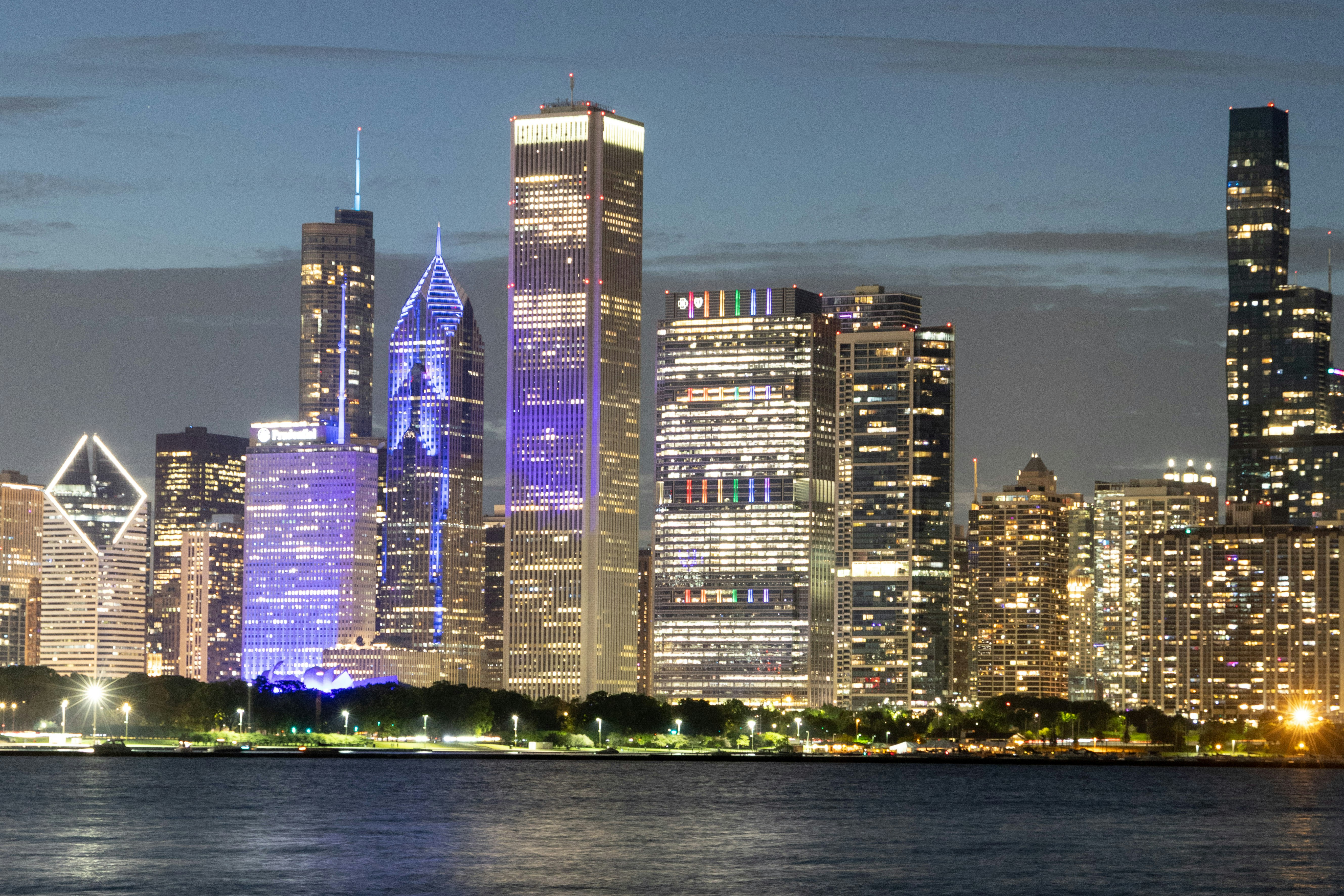 Illuminated Skyline Over Calm Waters at Dusk