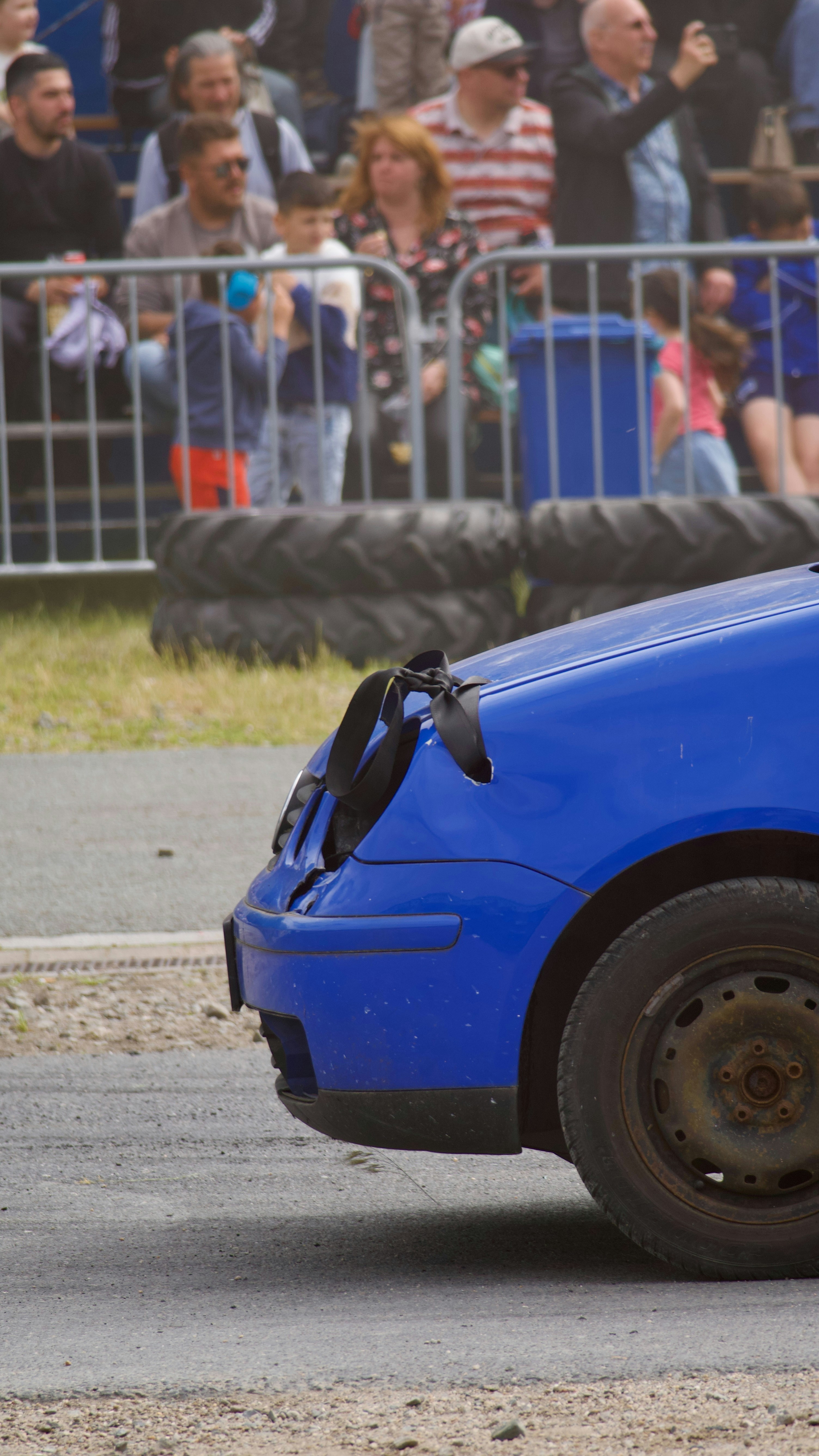 Blue Car, Crowd, and Tire Barrier: A Moment at the Track