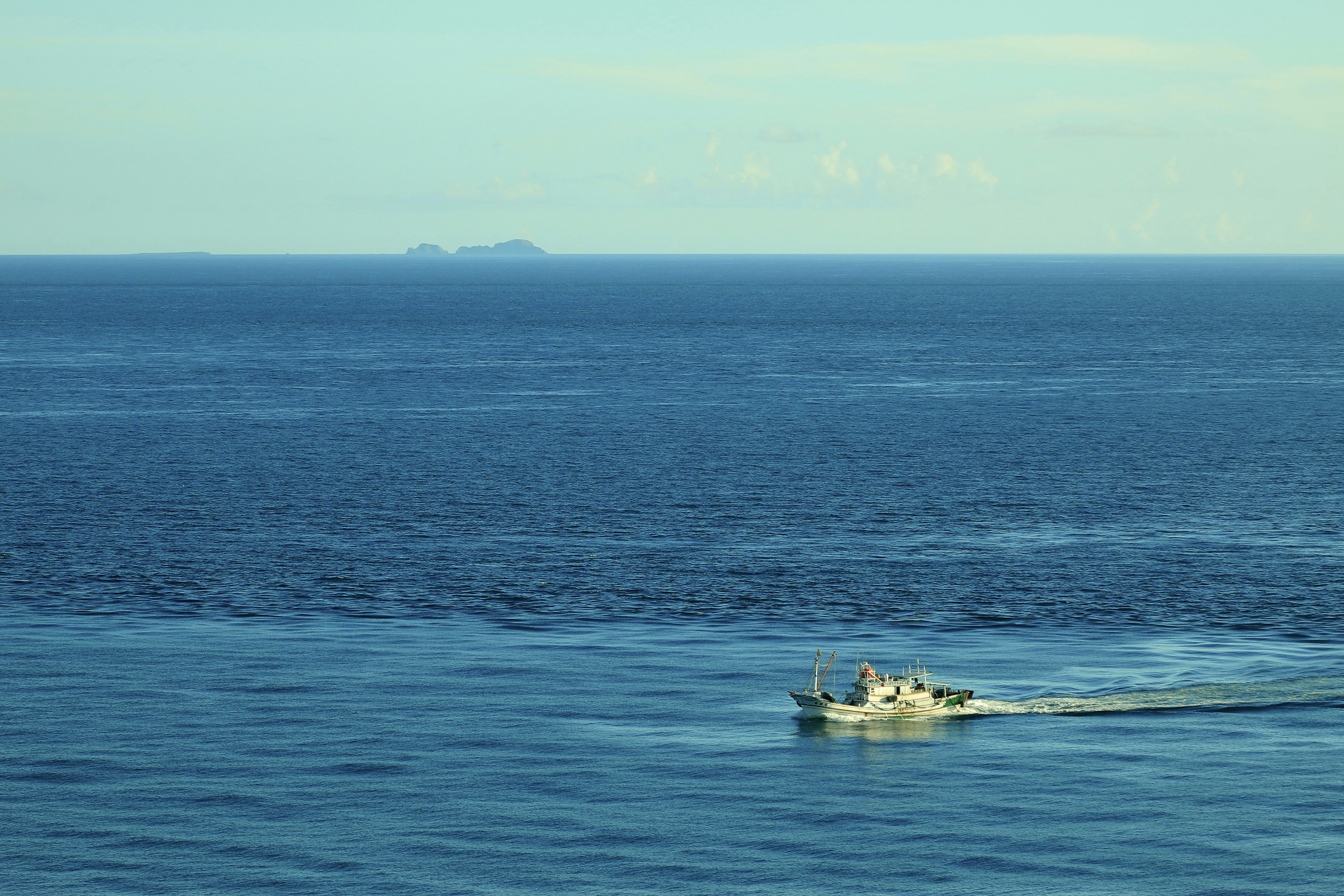 Boat Cutting Through a Calm Blue Expanse