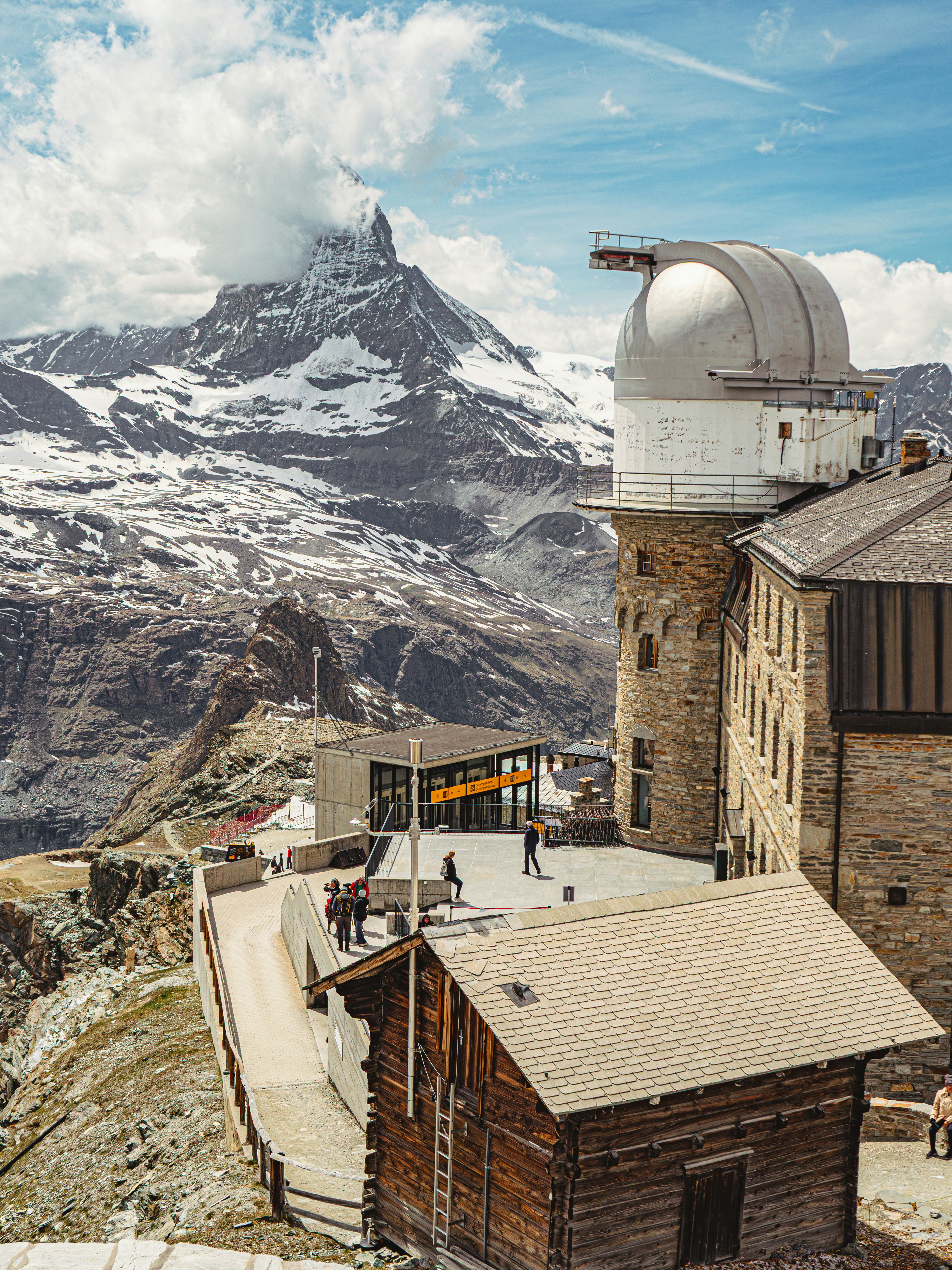 Iconic matterhorn and gornergrat observatory under a partly cloudy sky.