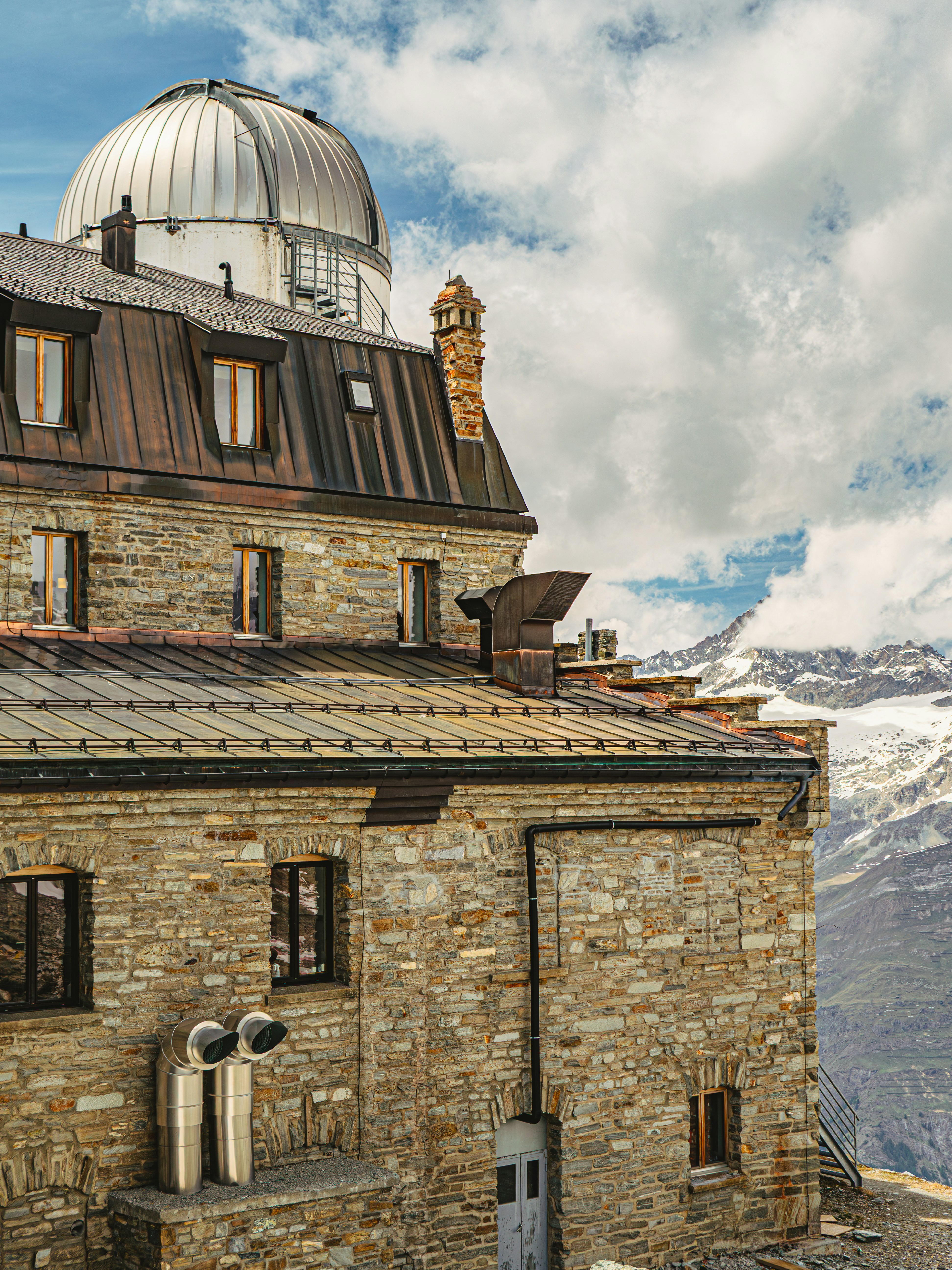 Stone Observatory Under a Silver Dome Against Alpine Sky