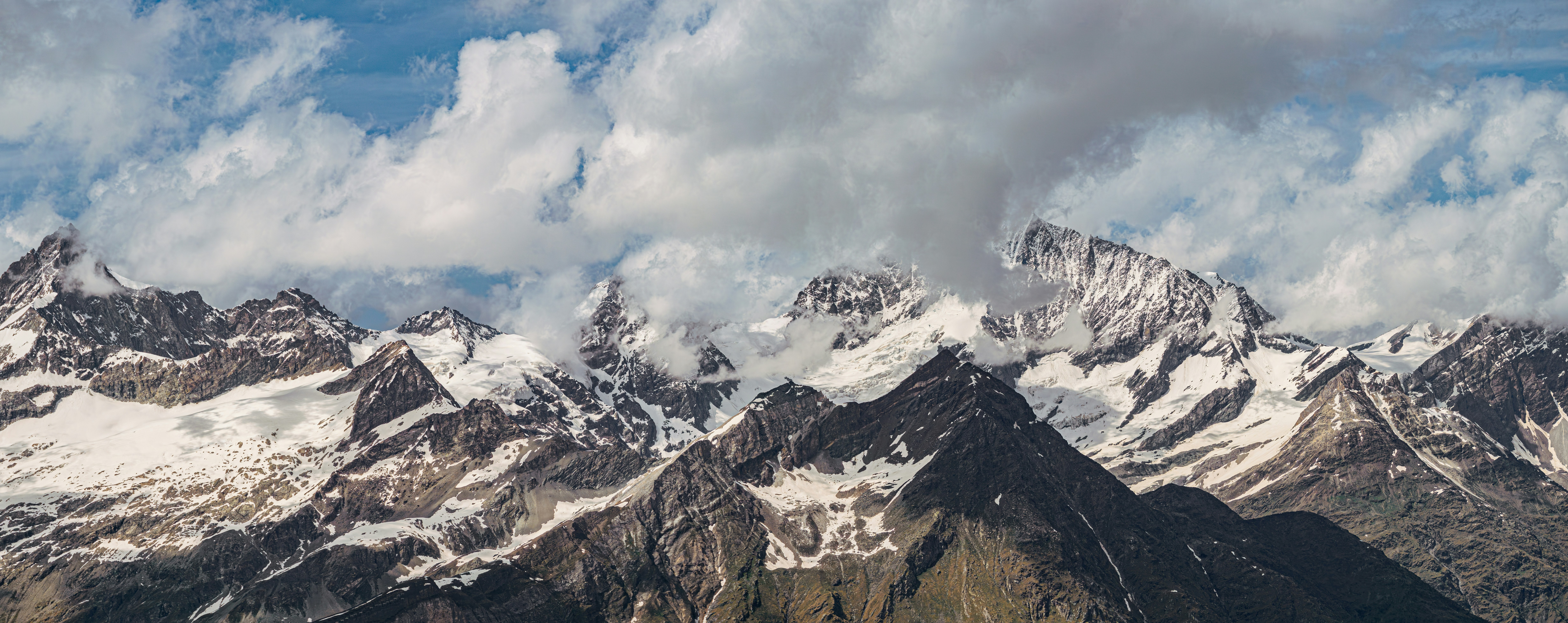 Ridge-Line Majesty: Snow-Capped Peaks Under Expansive Sky