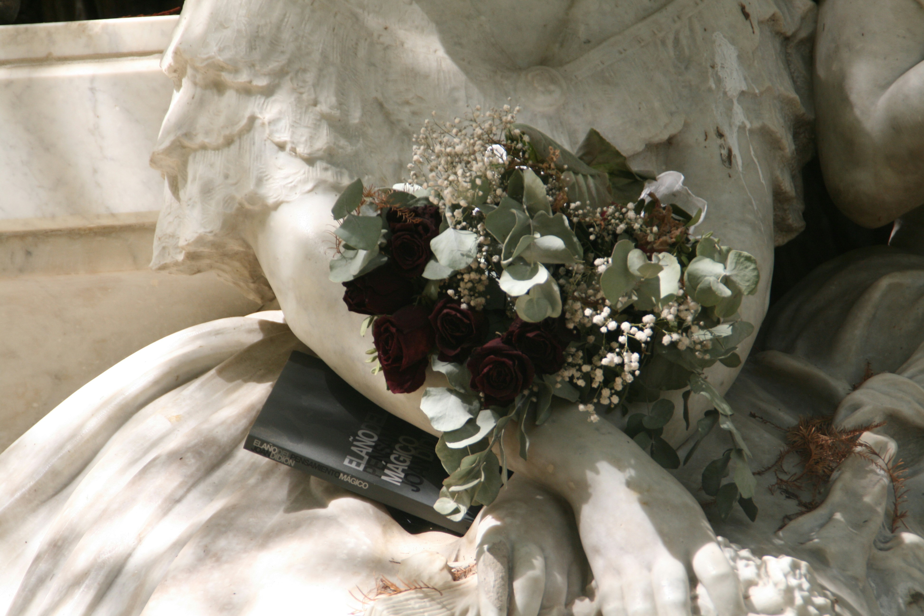 Silent Bouquet: A bouquet tucked into stone cherub relief