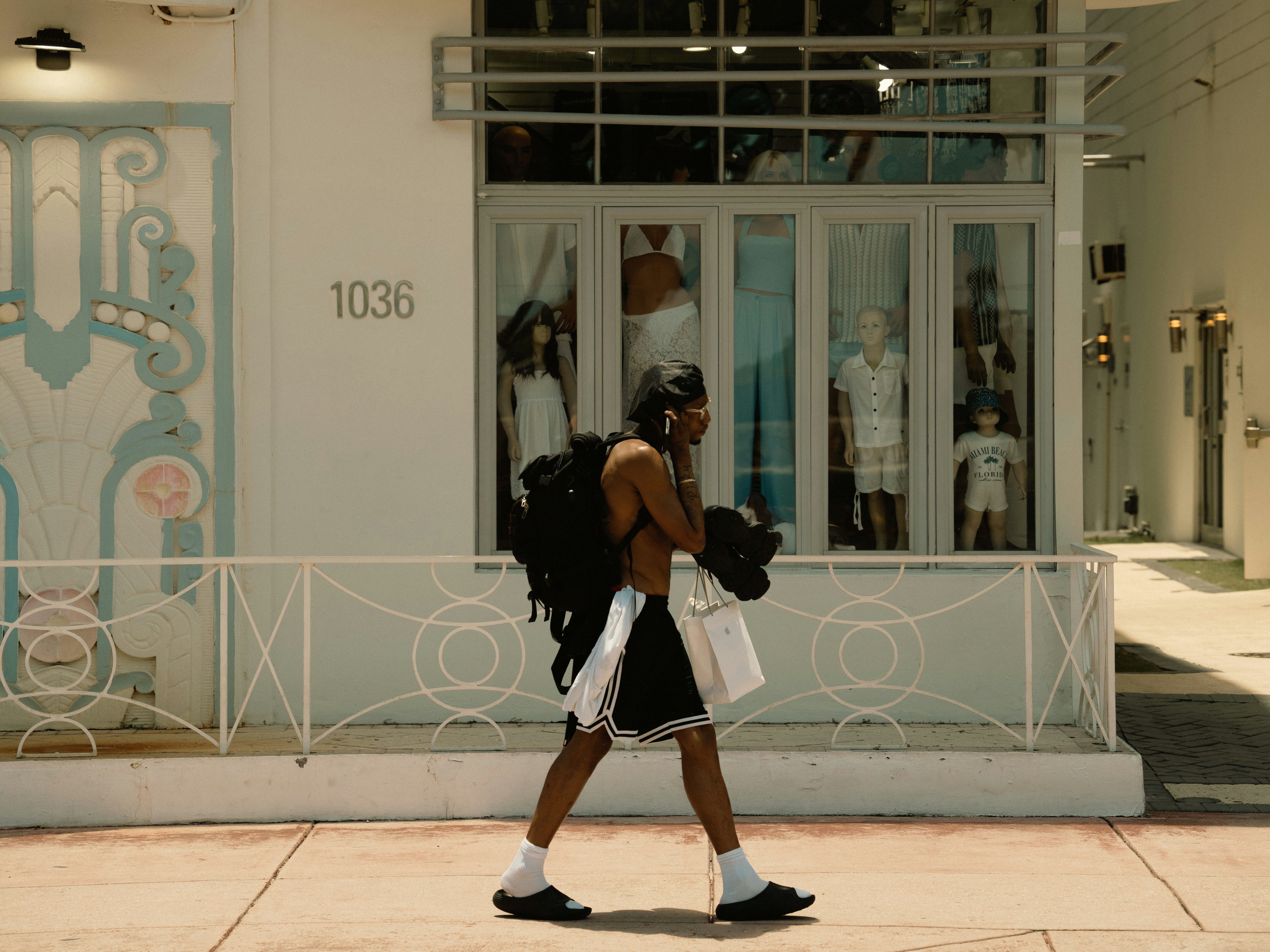 Crosswalk Stride: A Young Traveler Passes a pastel storefront