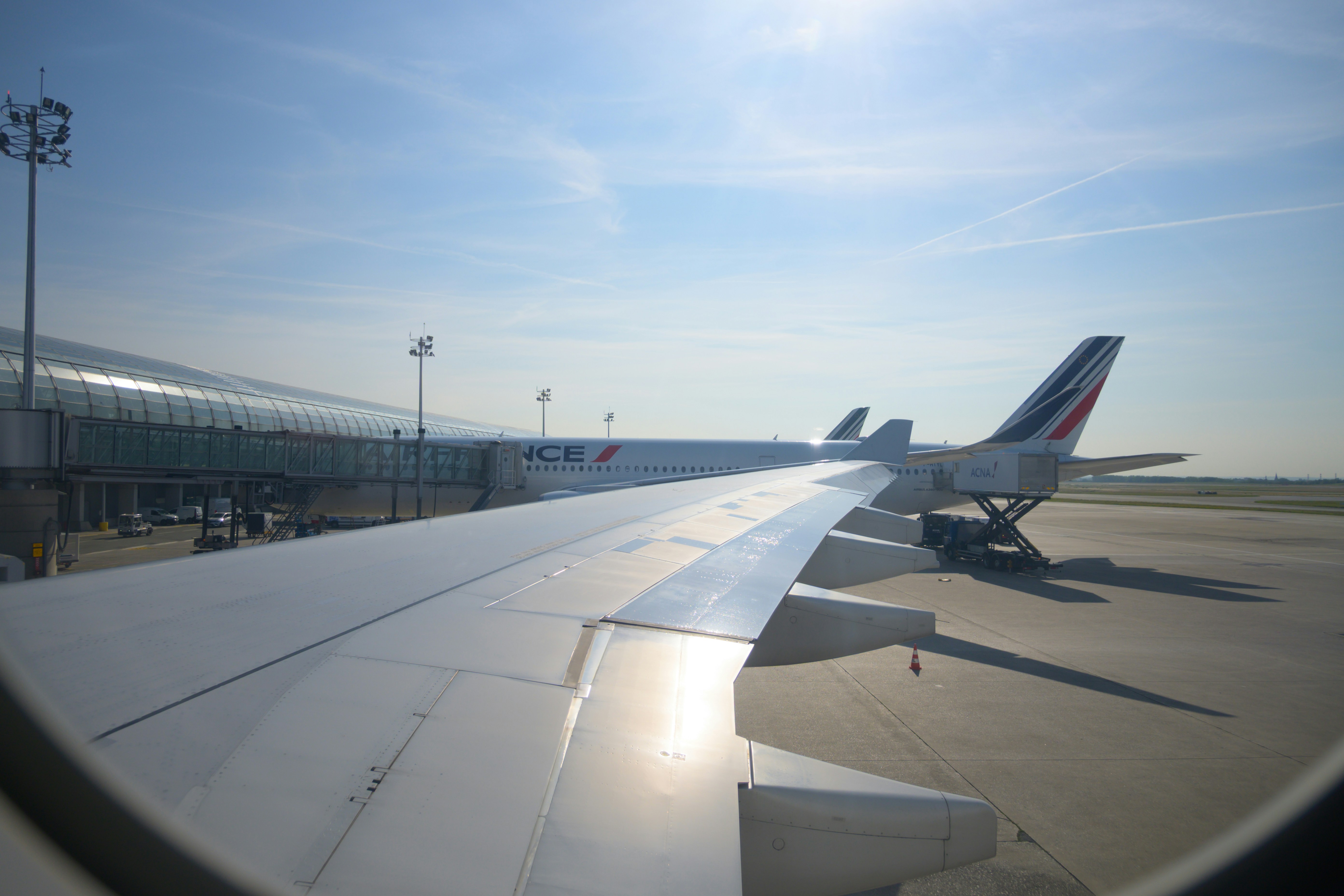 Airplane wing on a runway with other planes.