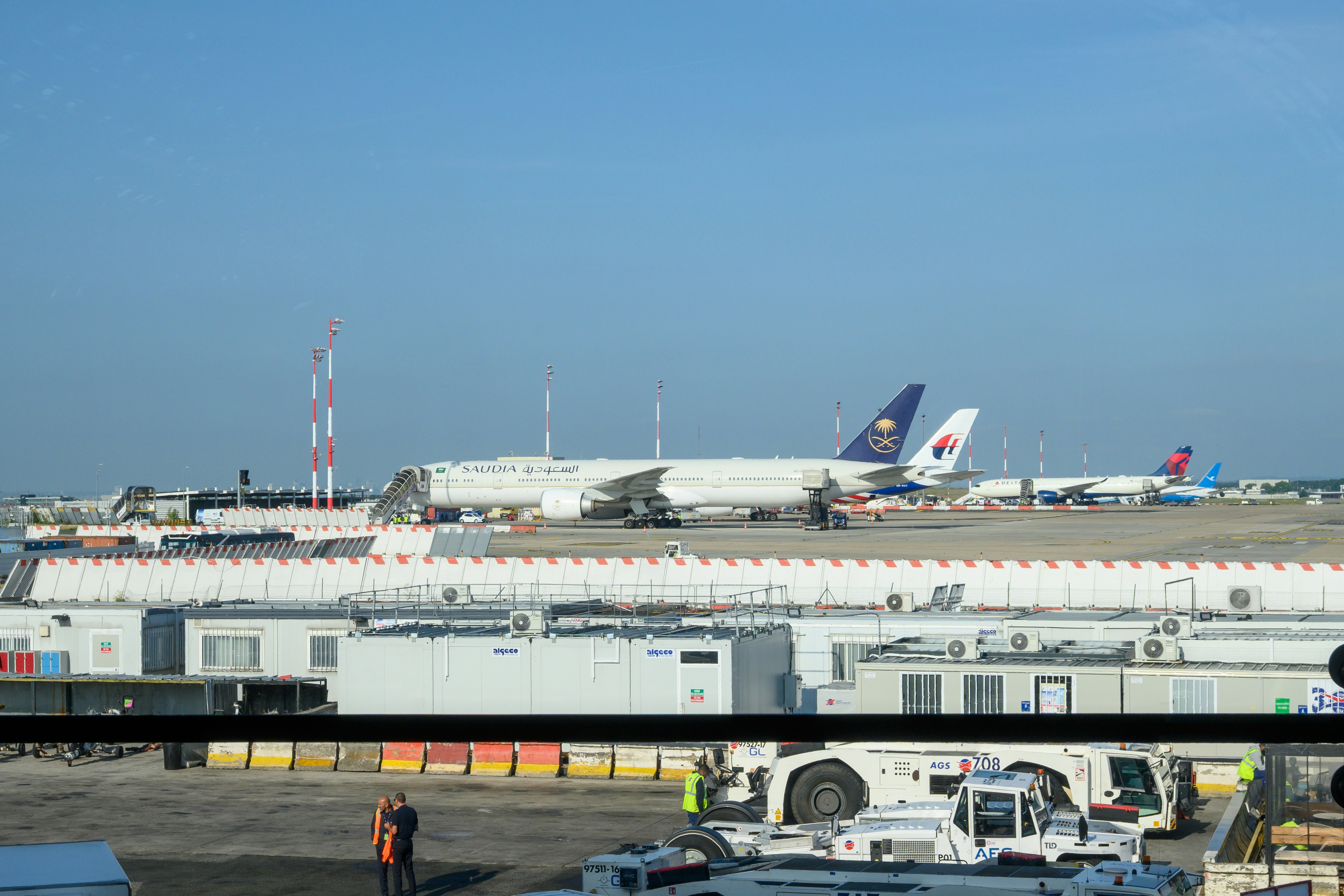 Airplanes parked at an airport terminal with ground equipment.