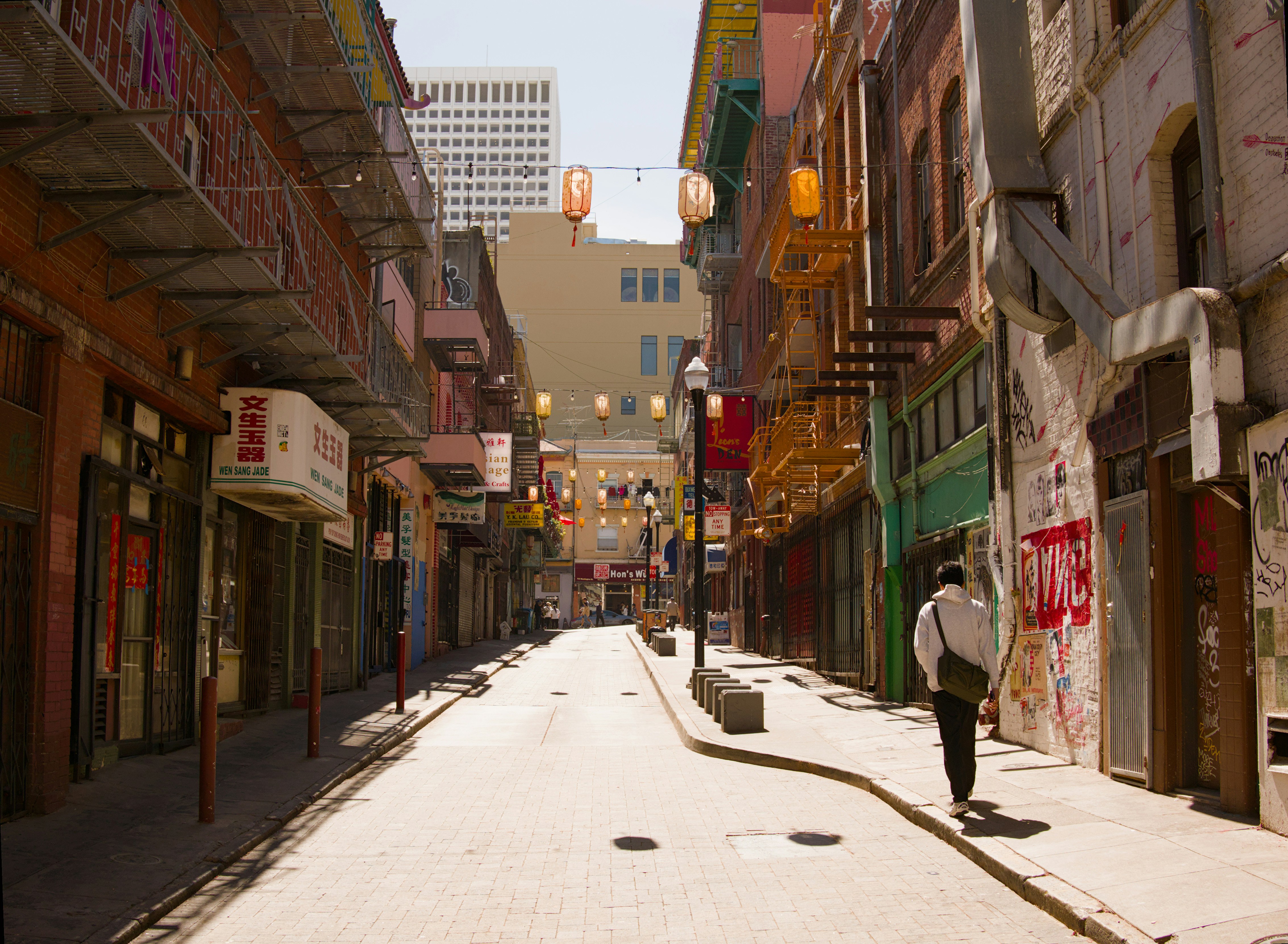 Sunlit Alleyway Between Echoing Storefronts