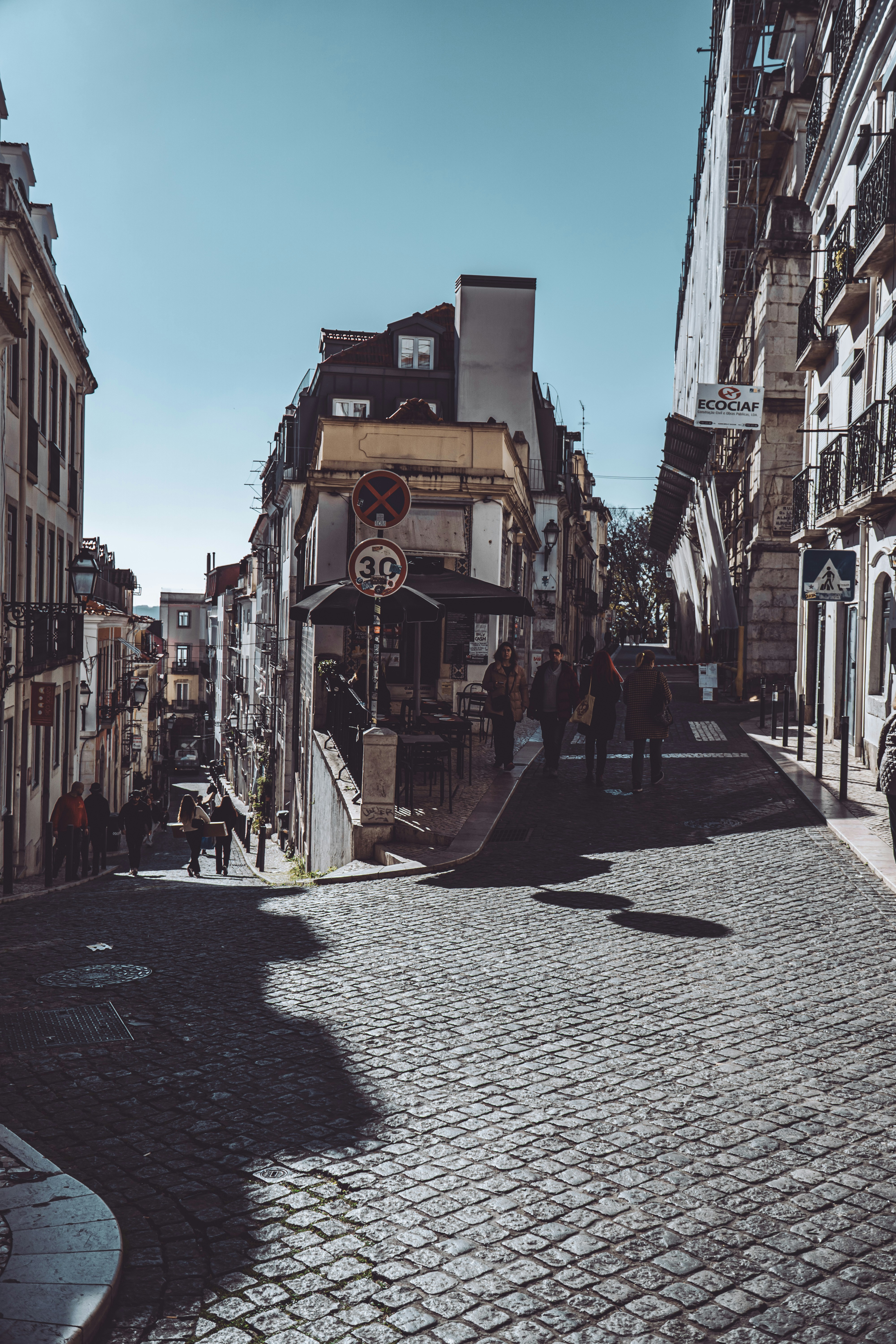 Cobbled Street Convergence: Shadows, Signage, and Stairwell Echoes