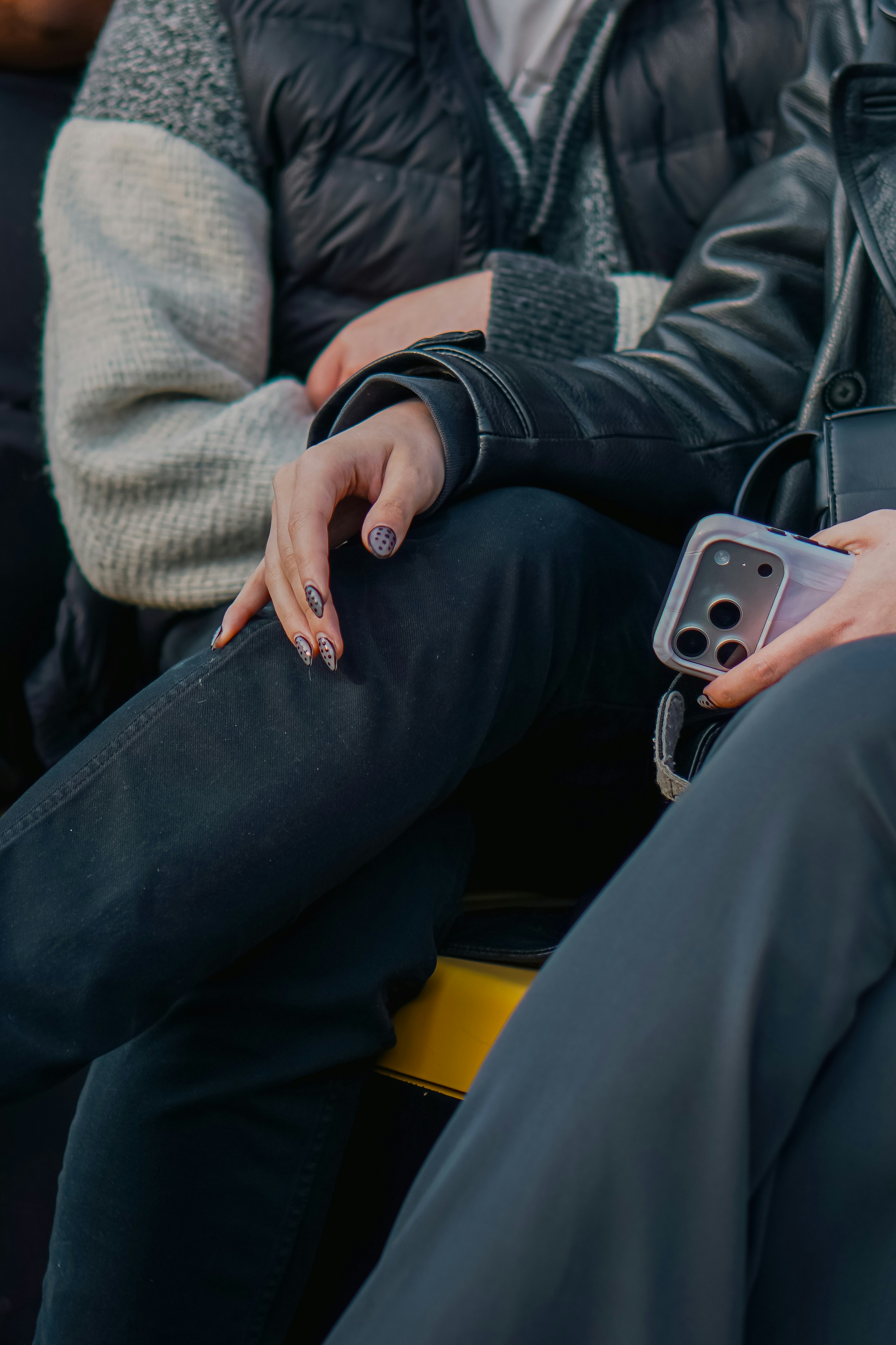 Quiet Urban Moment: Hands, Leather, and an Ice-Blue Phone