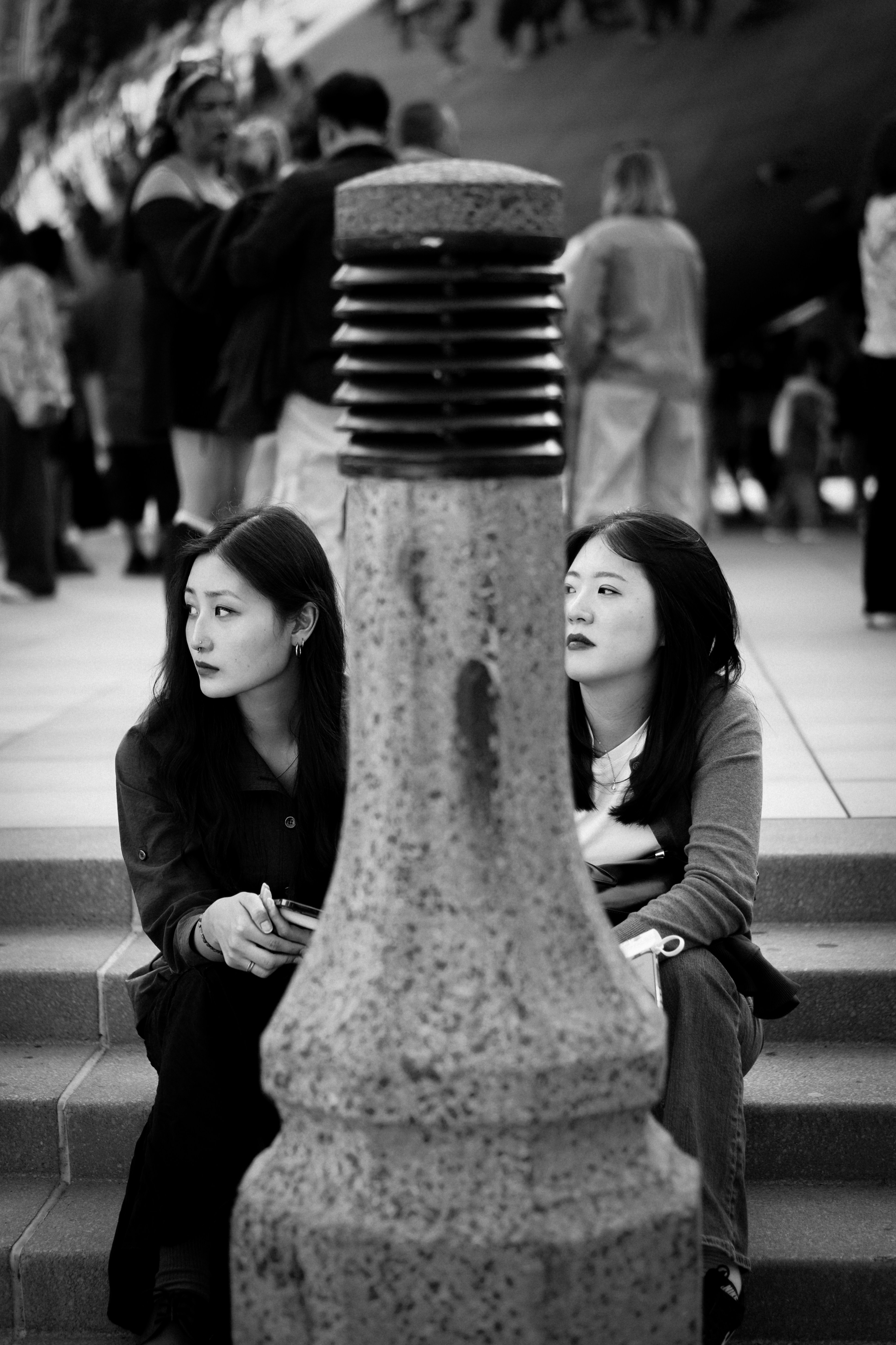Two Women by the Street Lamp: Quiet Gaze Across the Concrete Spire