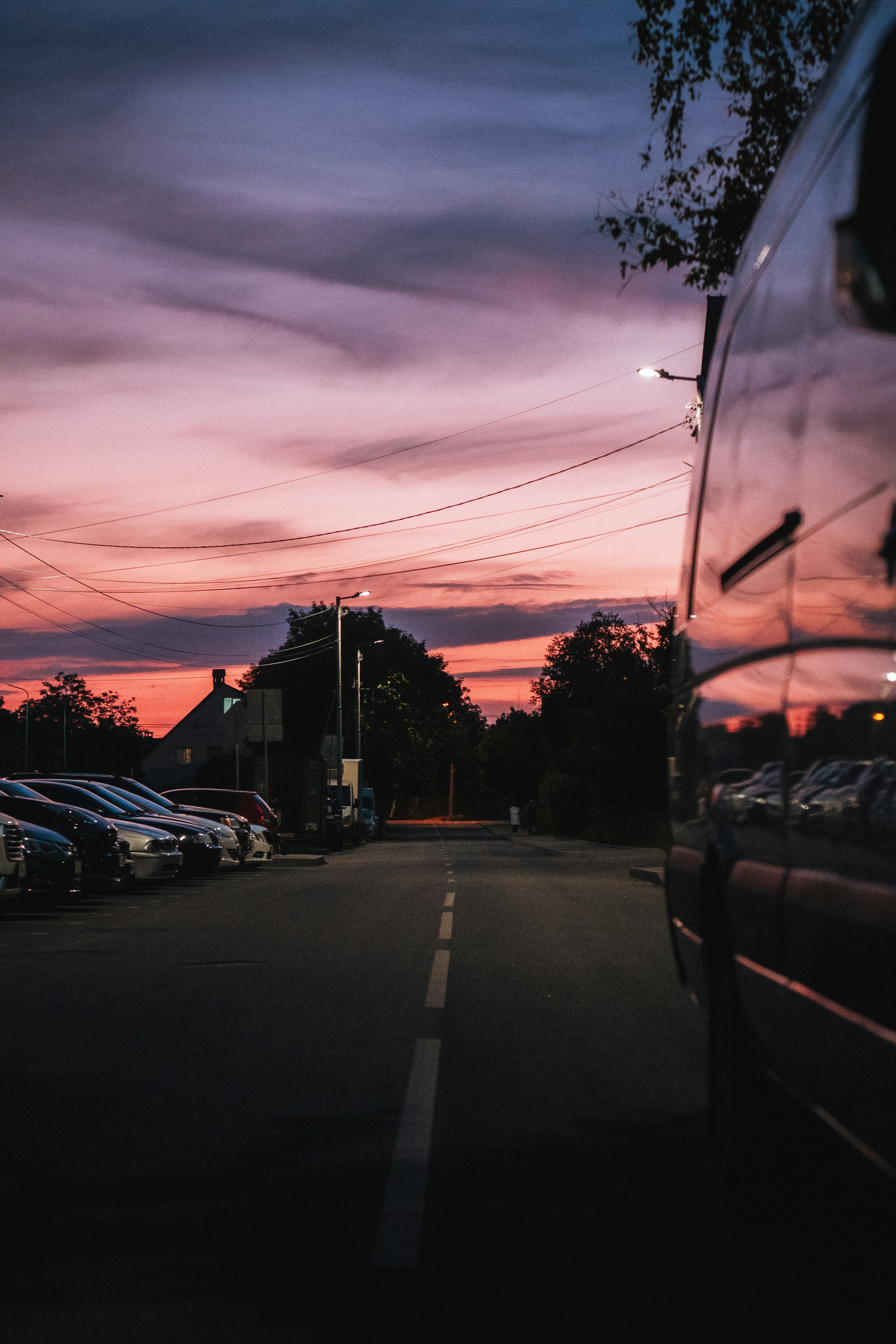 Dusk Street: A Vanishing Line of Cars and Neon Sky