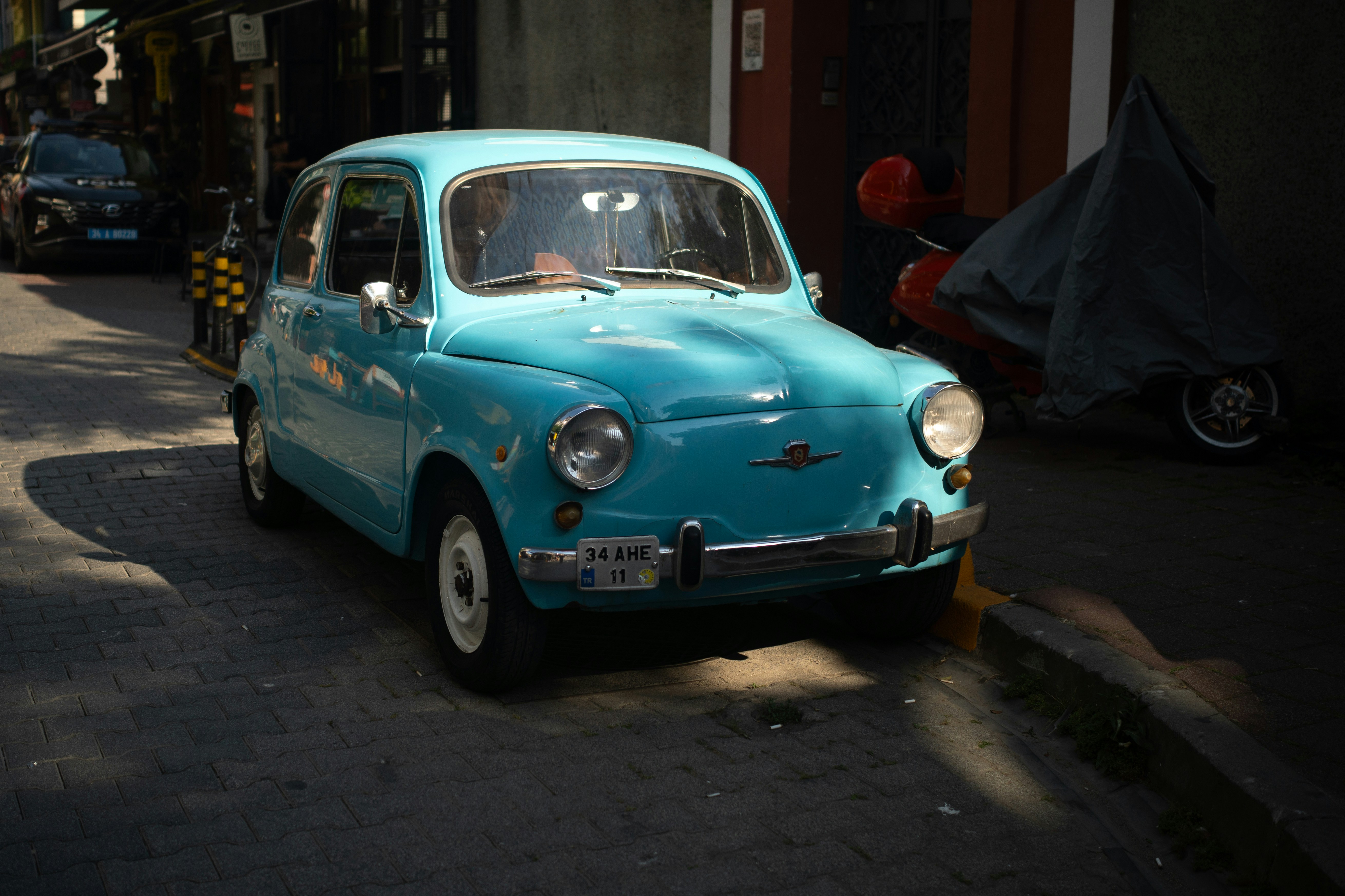 Turquoise Classic: A sunny curbside glimpse of a vintage sedan