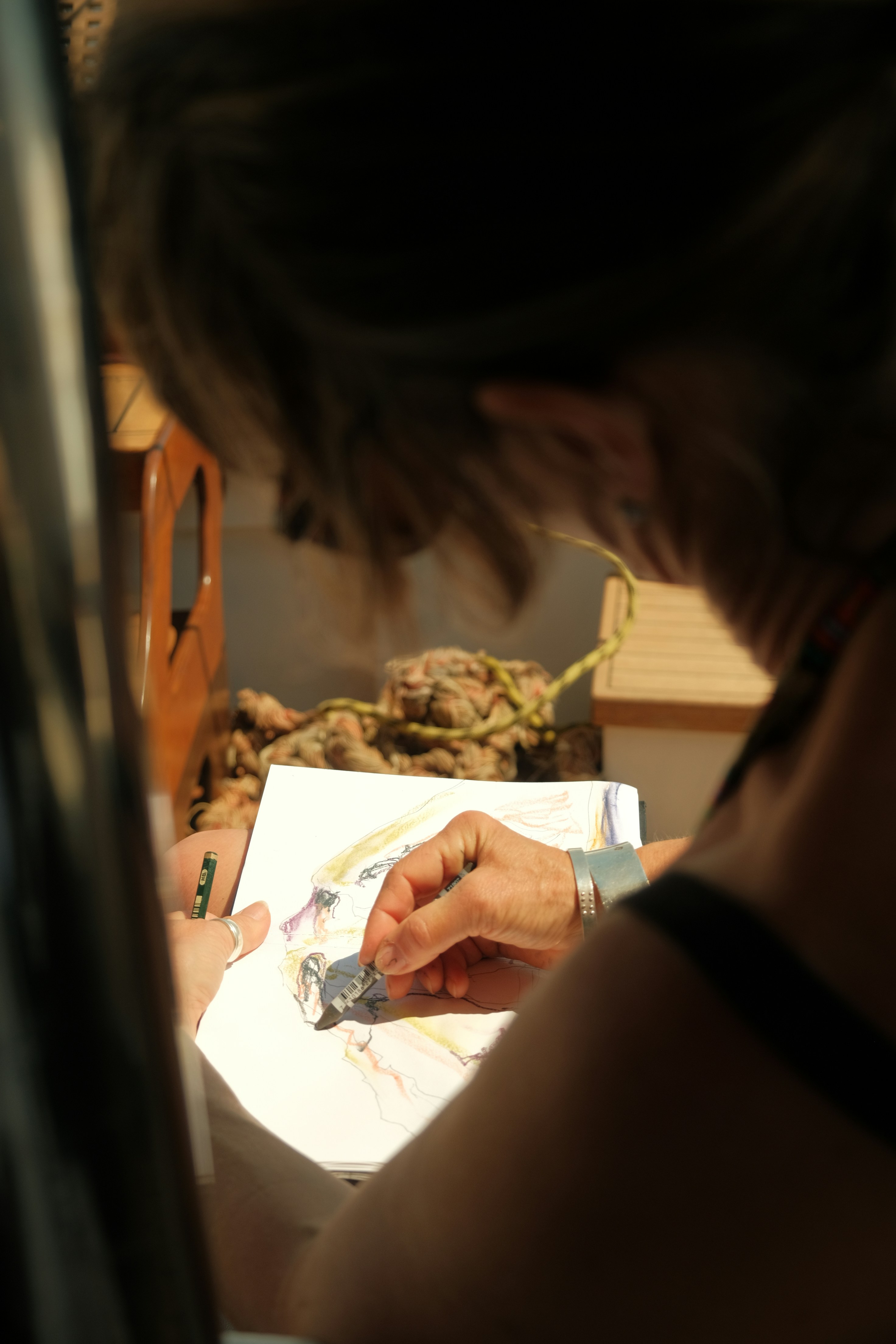 Sketching by Lantern Light: Focused Hands in a Cozy Studio