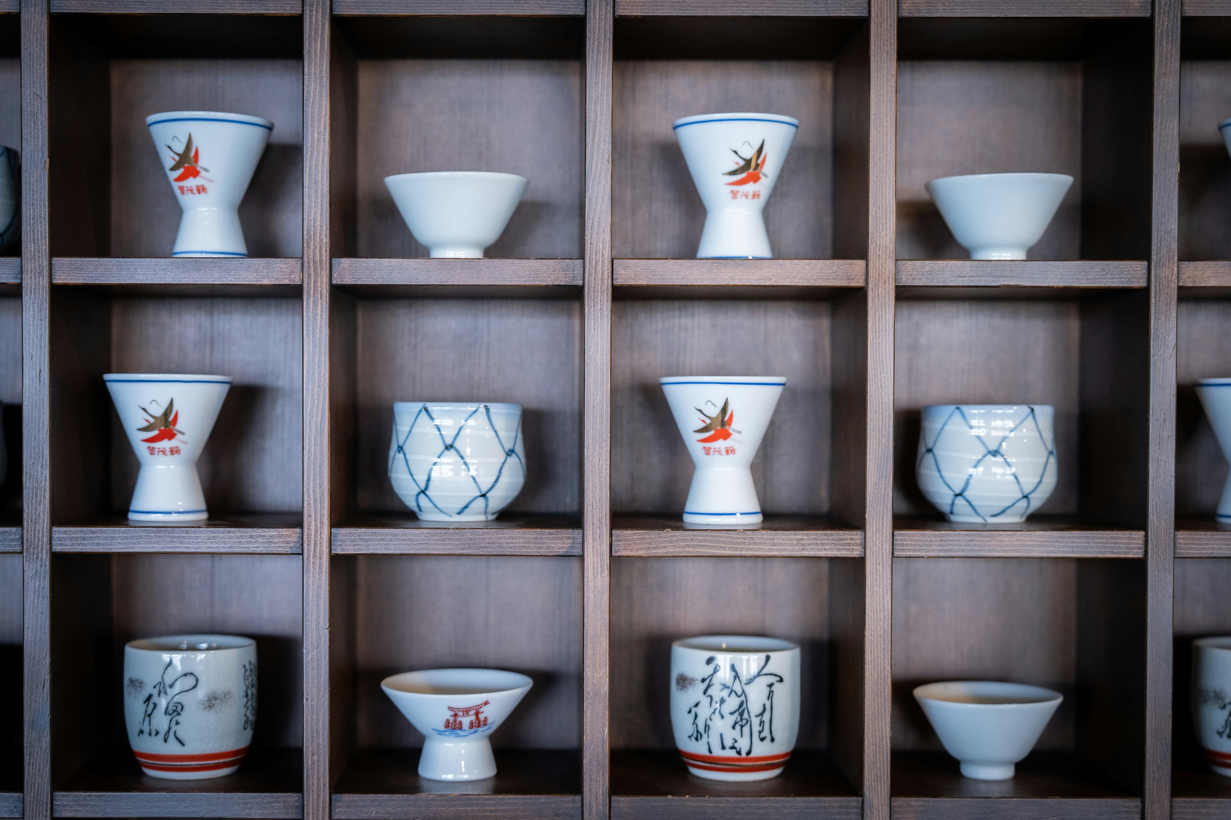 Symmetry in Clay: A Grid of Ceramic Vessels Framed by Wooden Shelves