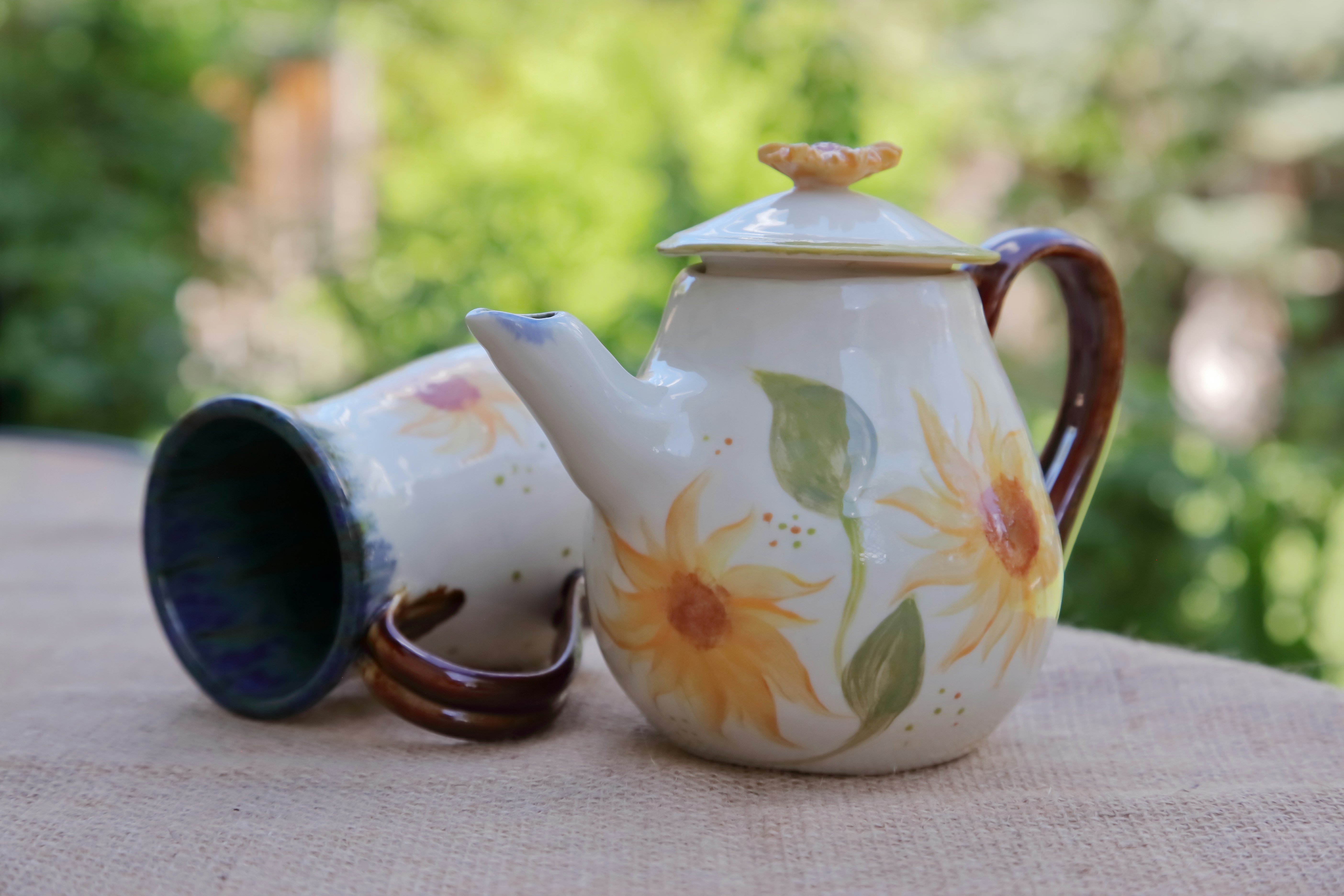 Sunlit Tea Bloom: A Floral Teapot Resting on Burlap