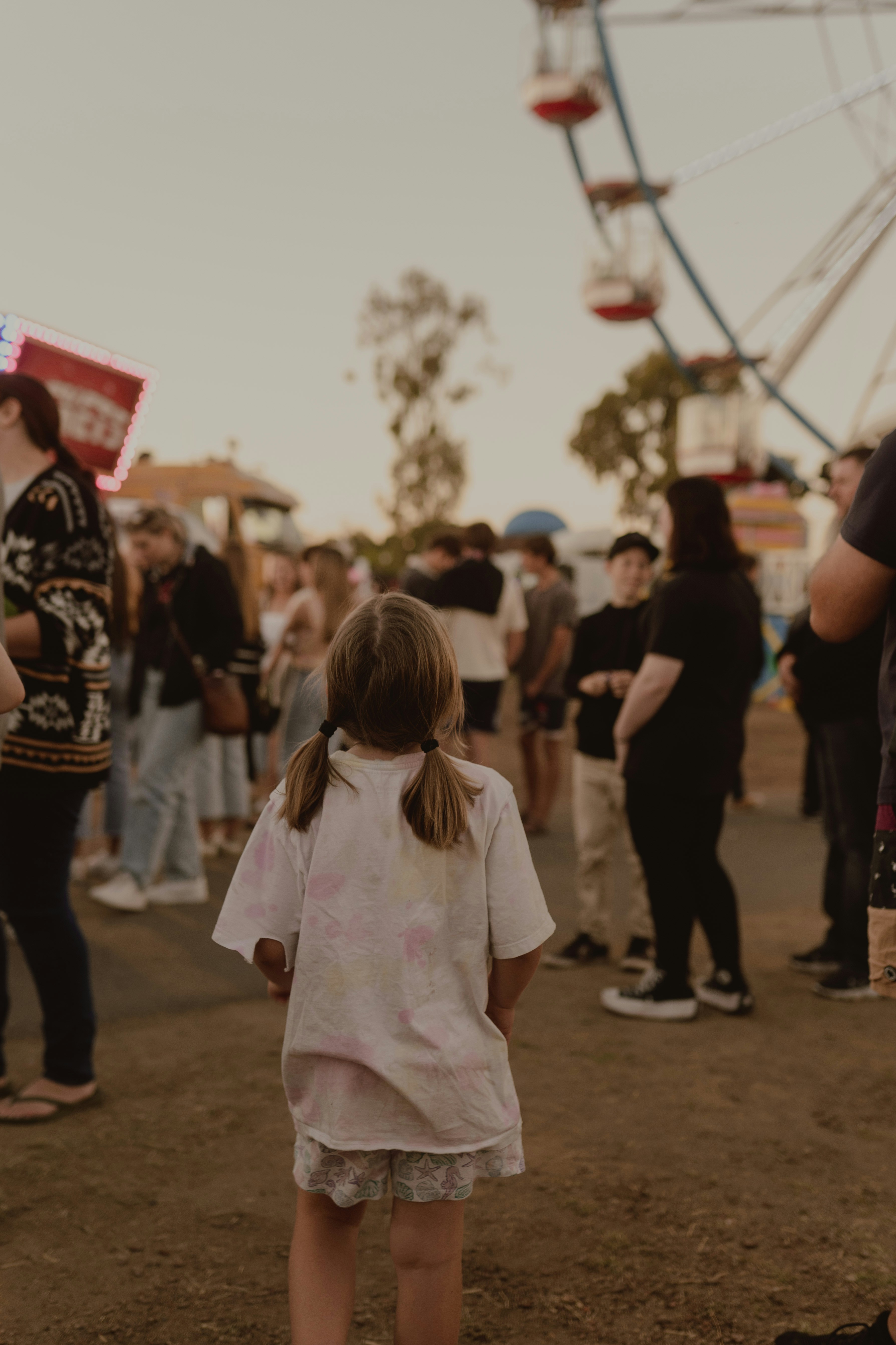 Child at the Carnival: A Quiet Moment Among the Crowd