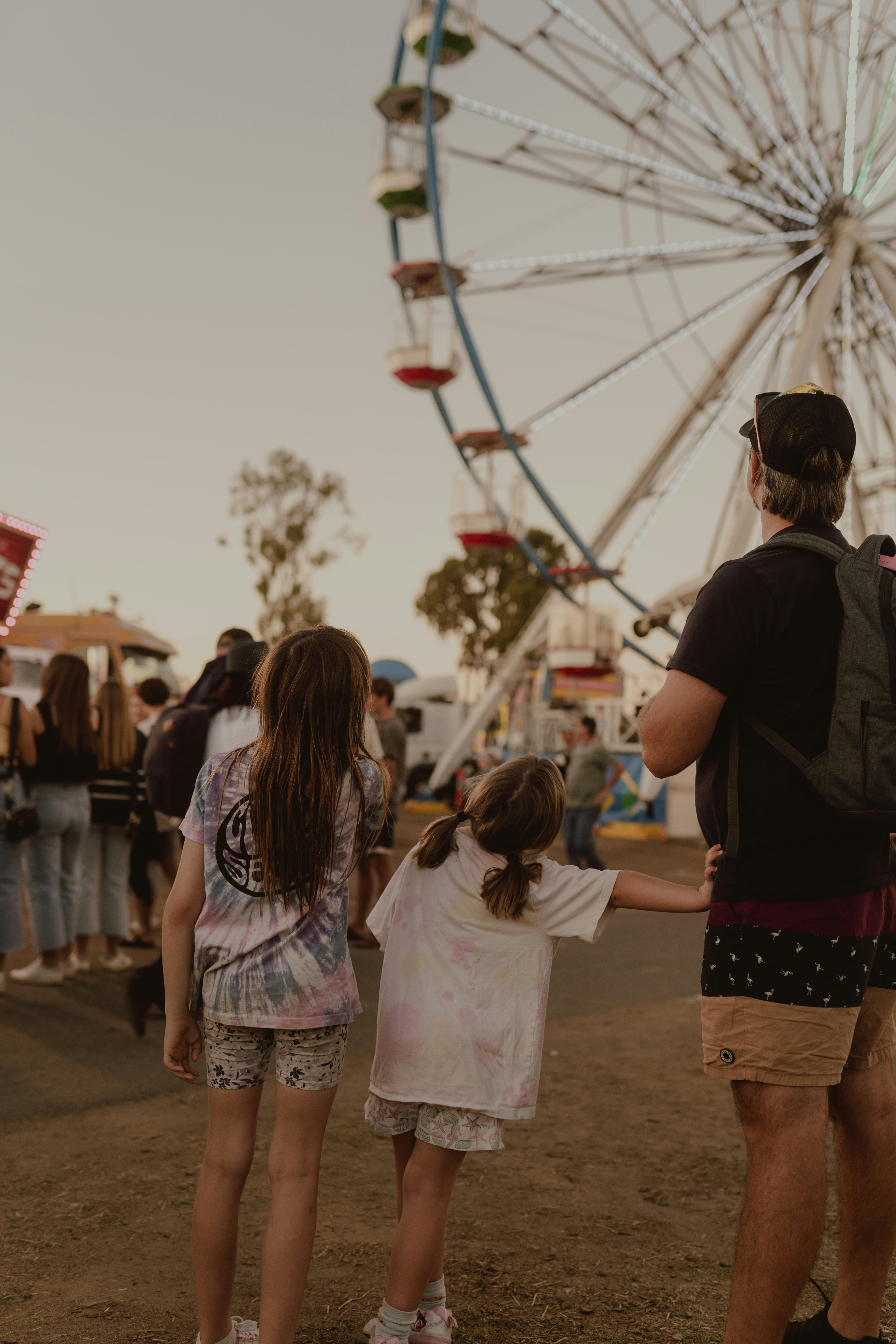 Pastel Carousel Moment: A Family Amid the Ferris Wheel Glow