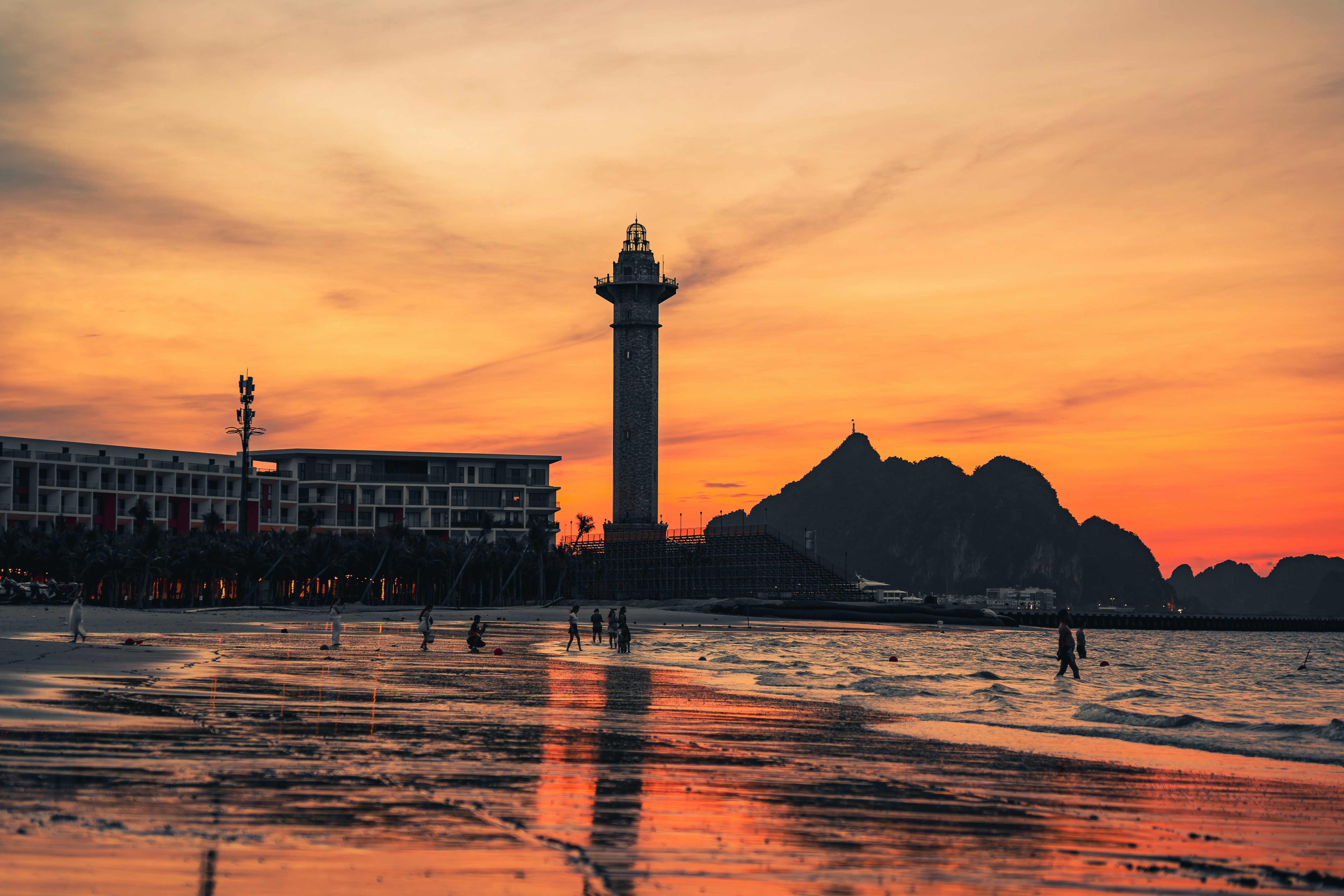Lighthouse at Sunset: Silhouettes Beyond a Glassy Shore