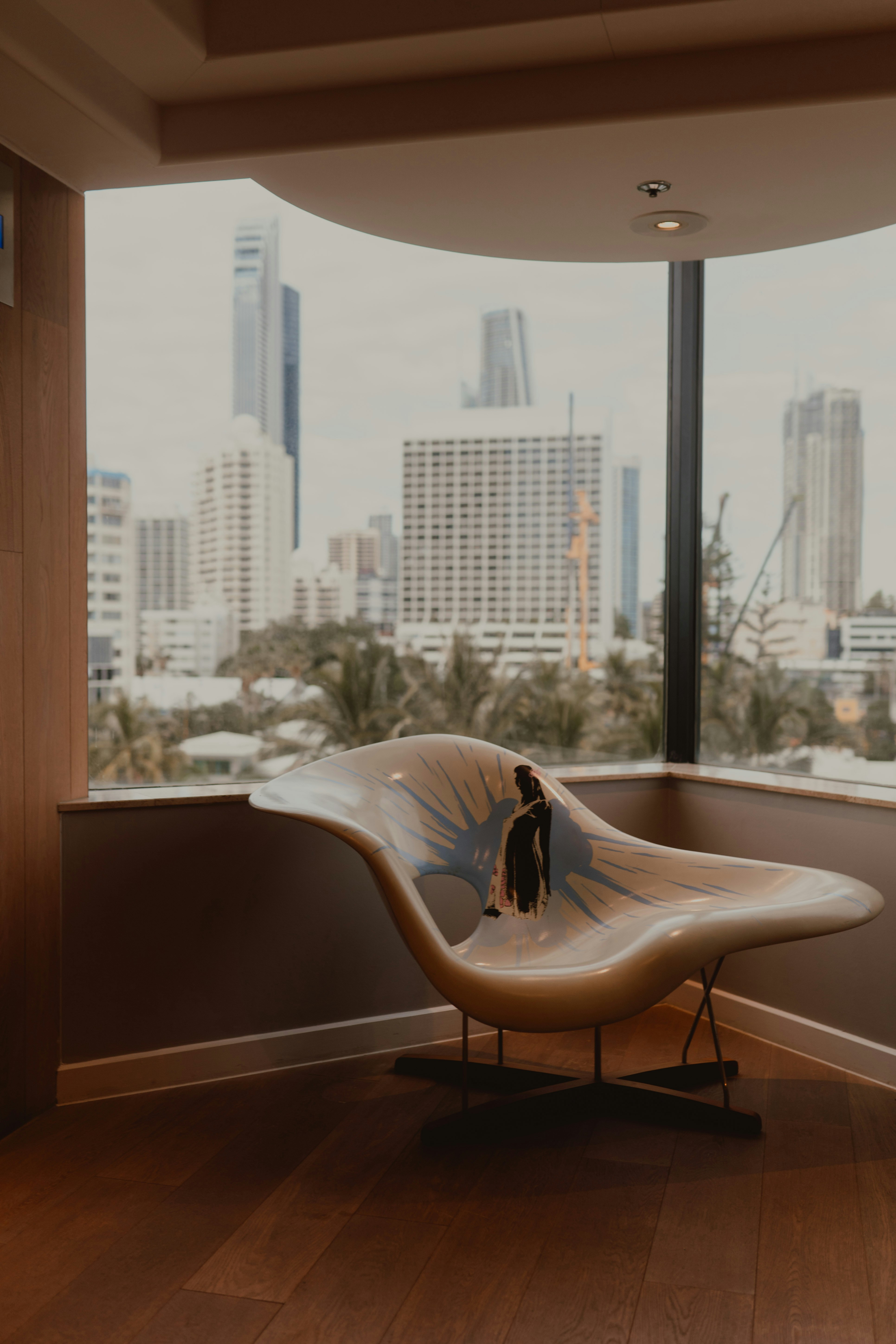 A Sculpted Lounge Seated Against a Cityscape Window