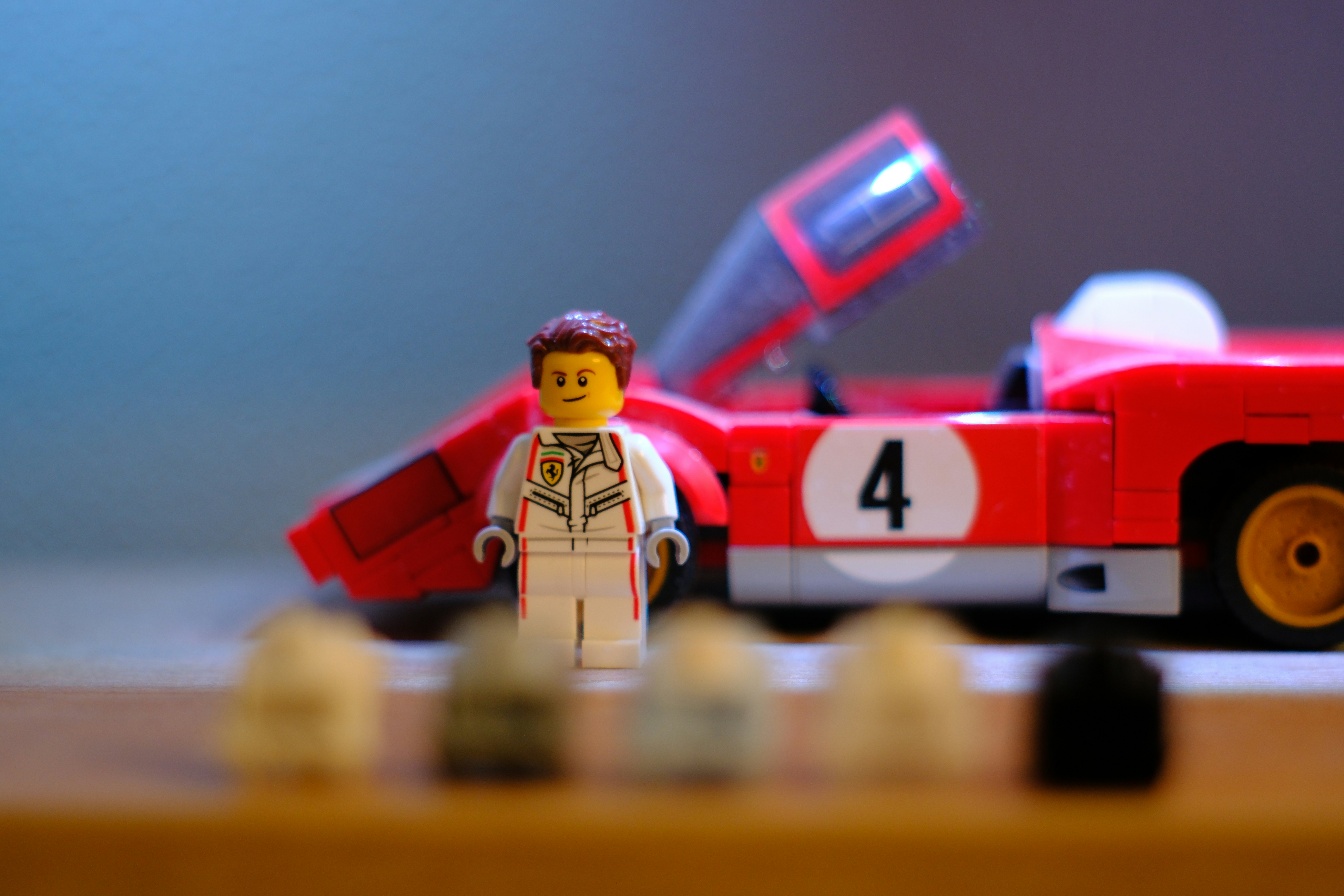 Mini racer at the ready: a LEGO driver stands before the red race car